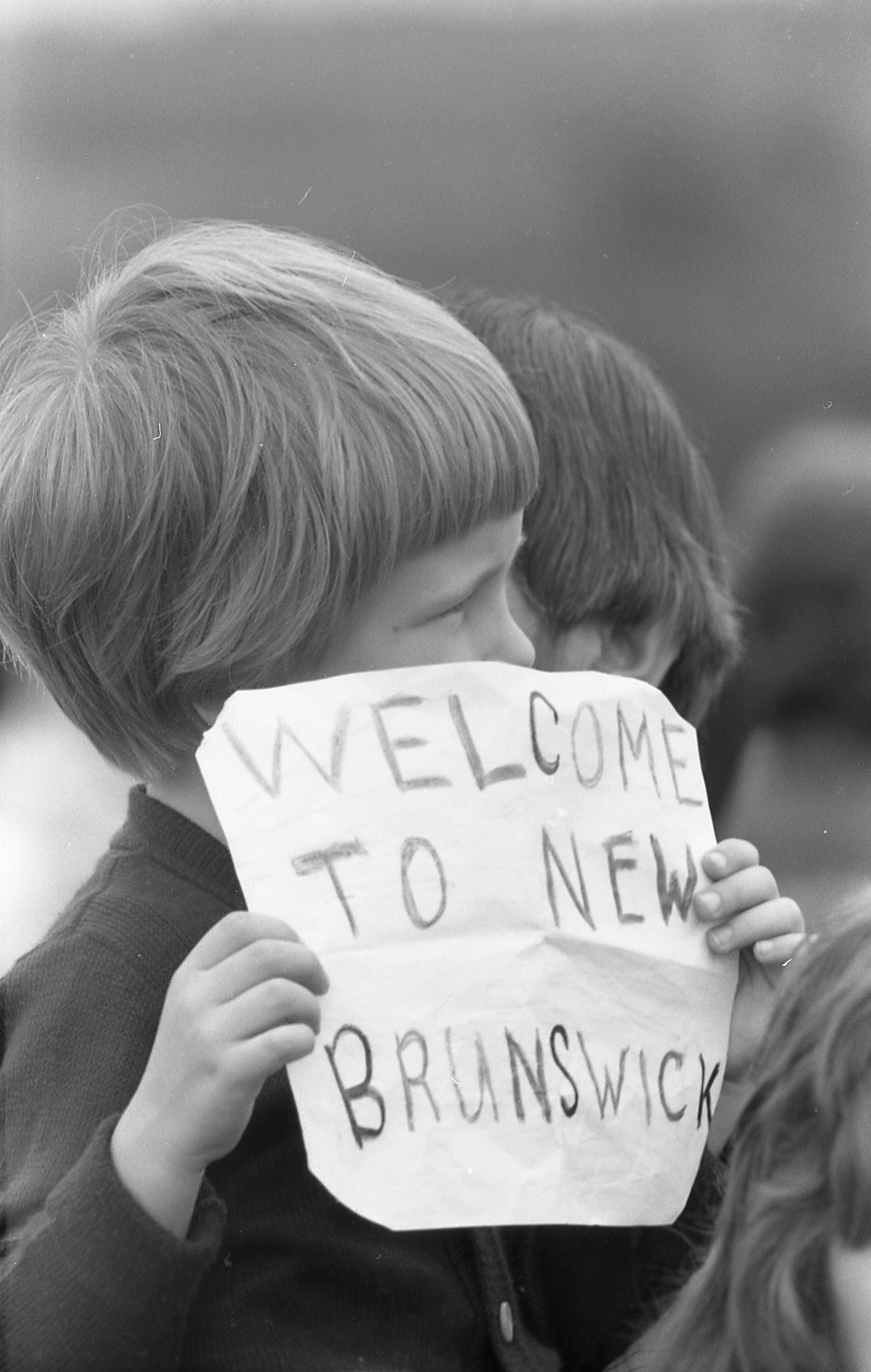 A young boy holding a welcome to new brunswick sign photo – Free ...