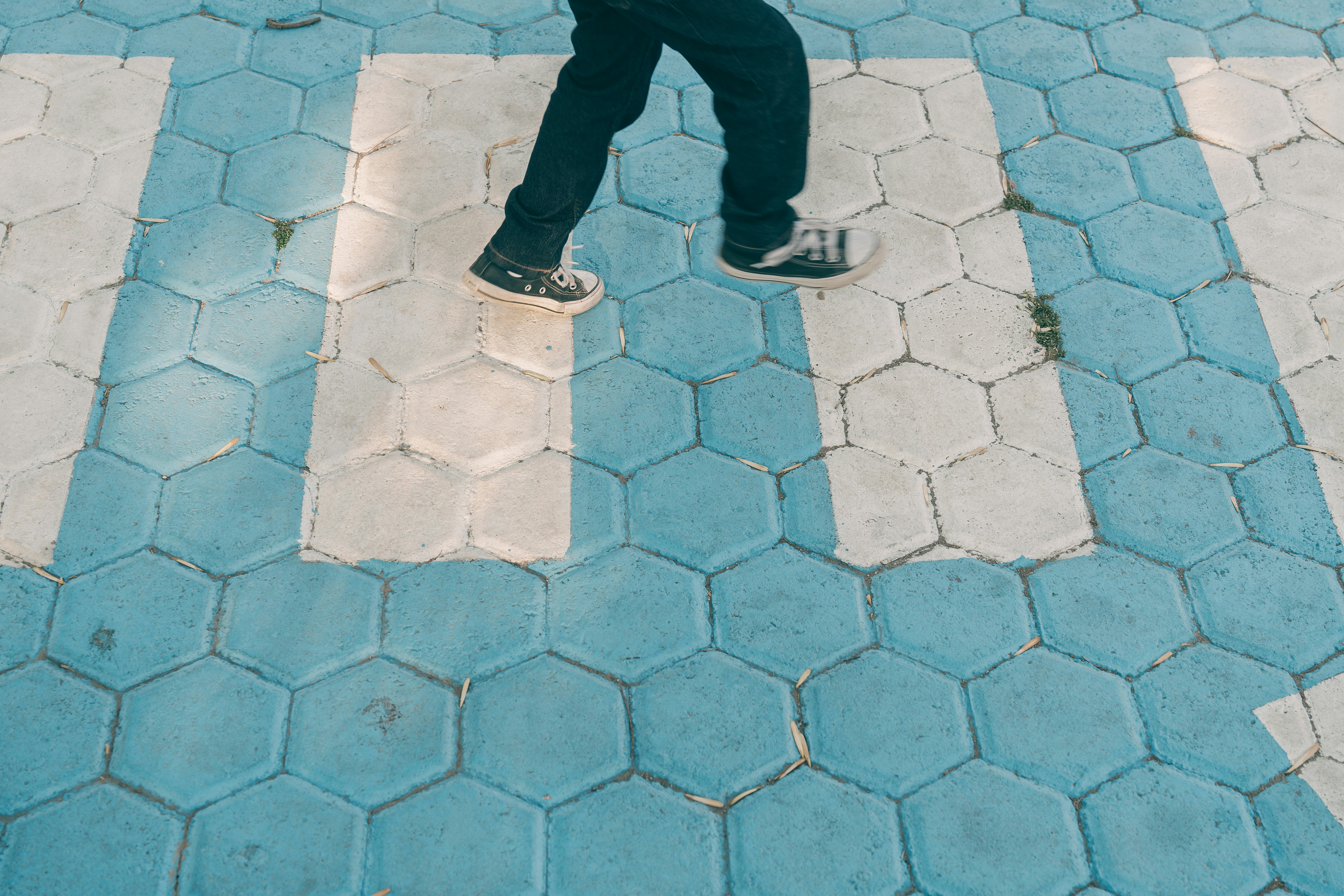 Blue Hex Tile Moment: Sneakers Paused Mid-Step on a City Tile Street