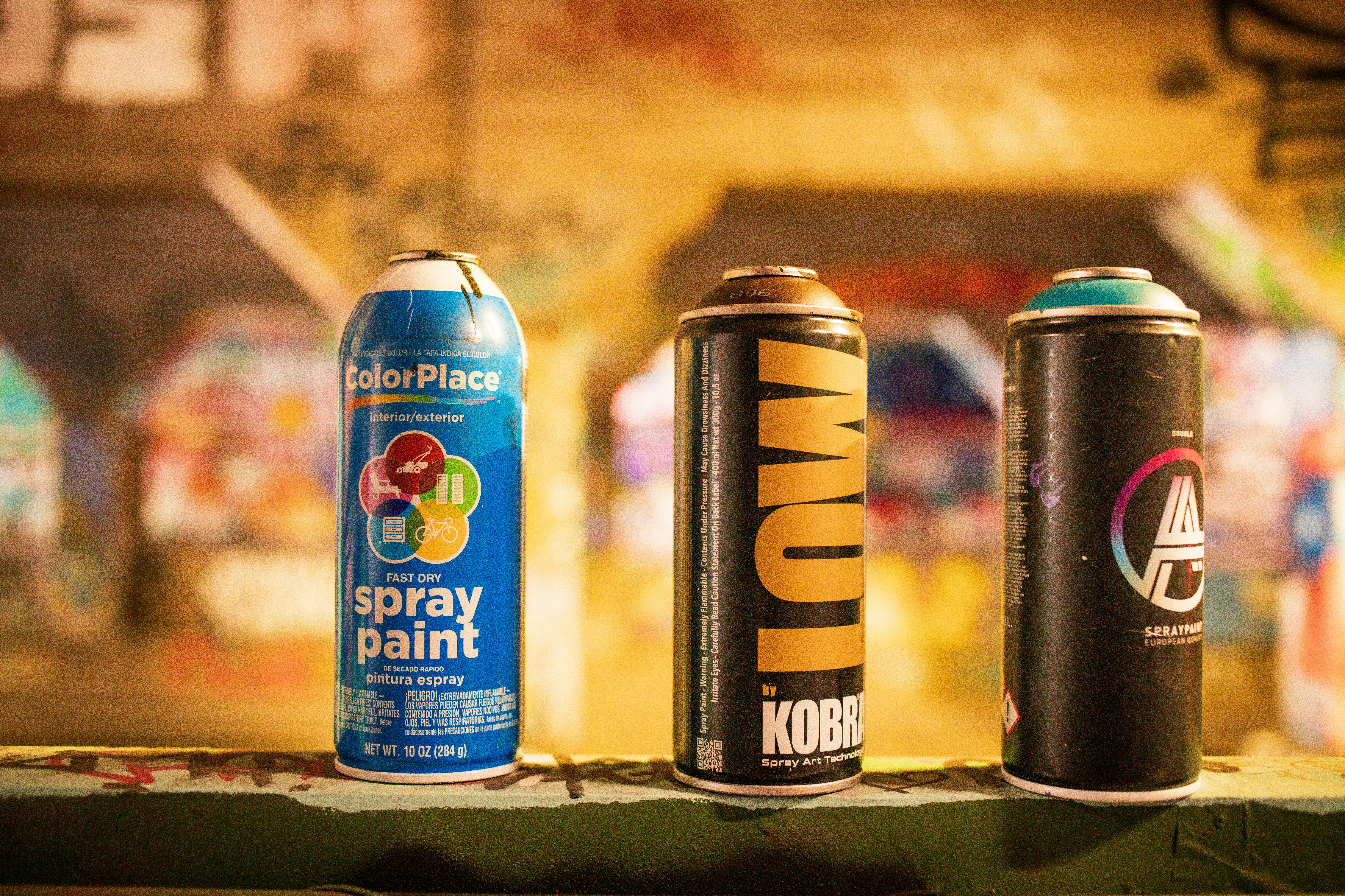 Three cans of spray paint sitting on a window sill photo – Free Art ...