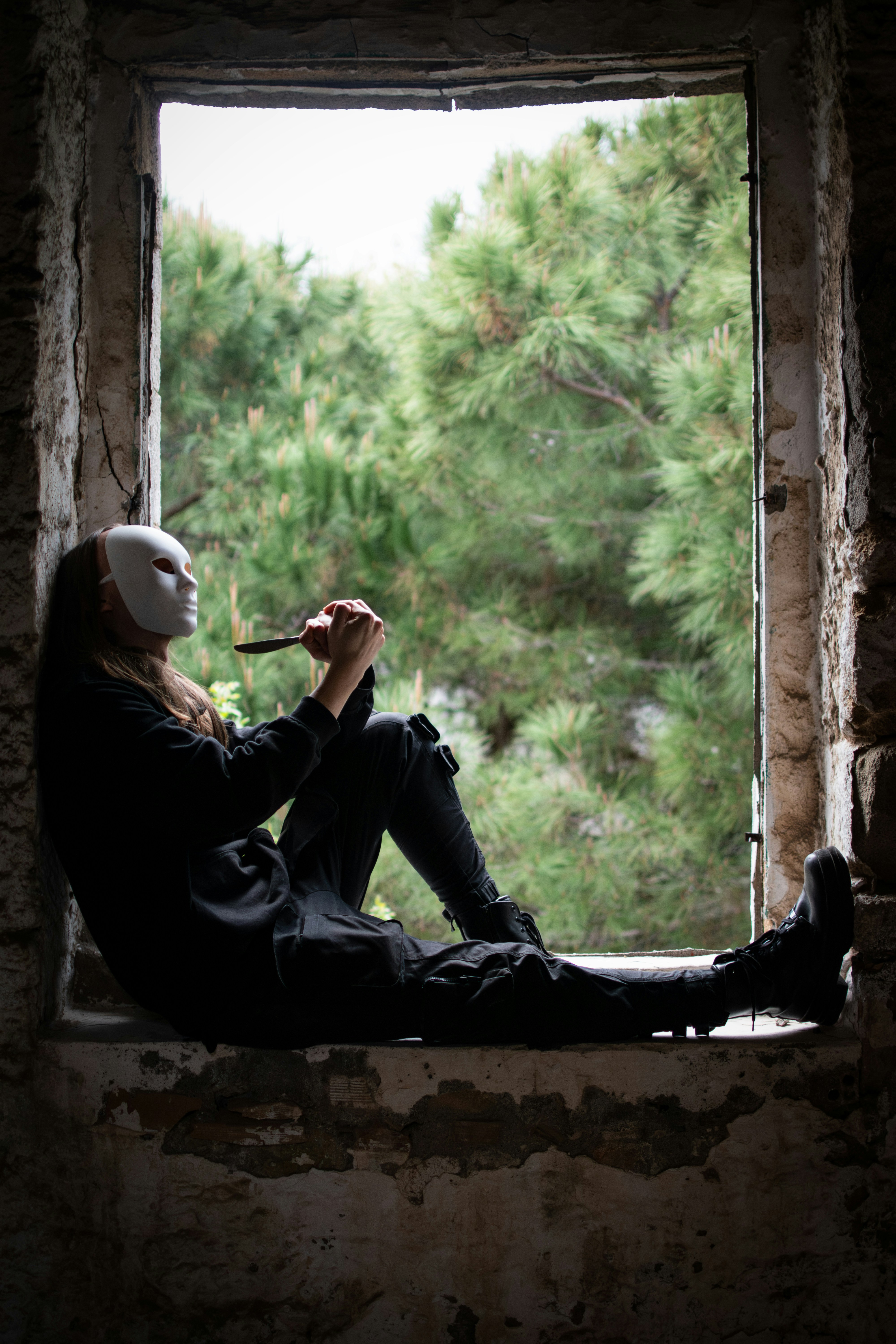 A woman sitting on a window sill smoking a cigarette photo – Free Grey ...