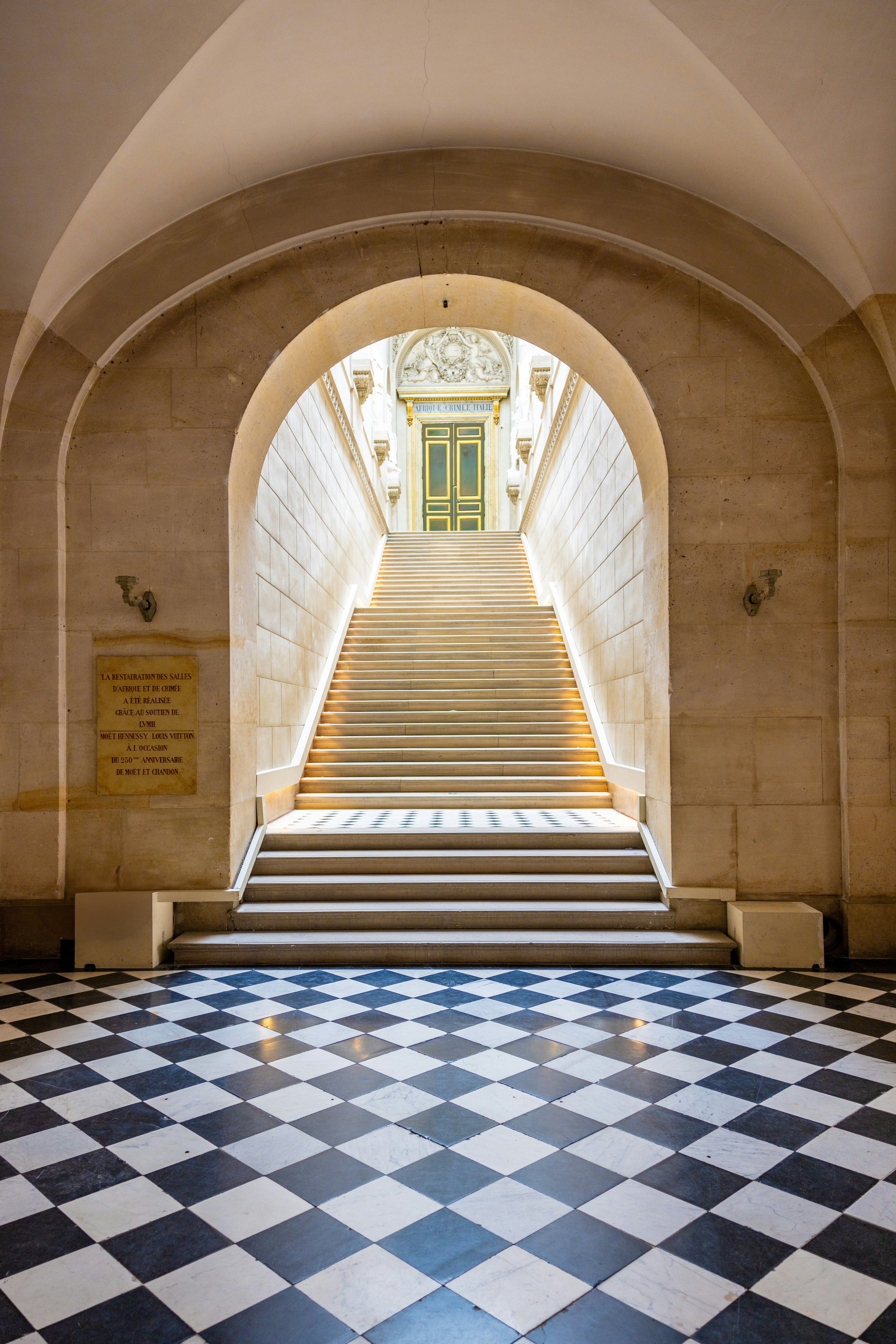 A hallway with a checkered floor and stairs photo – Free Staircase ...