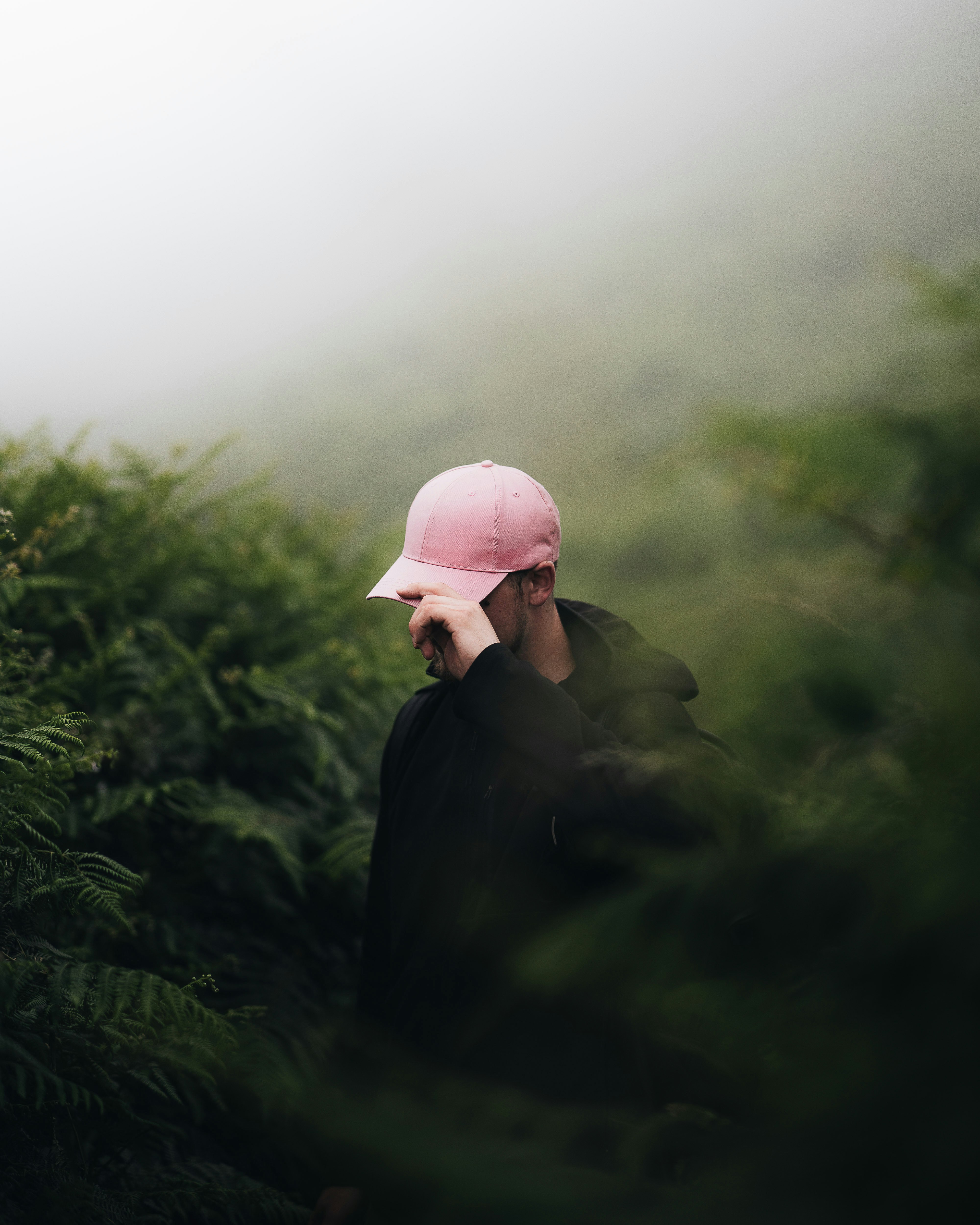 Une personne portant un chapeau rose marchant dans une forêt photo ...