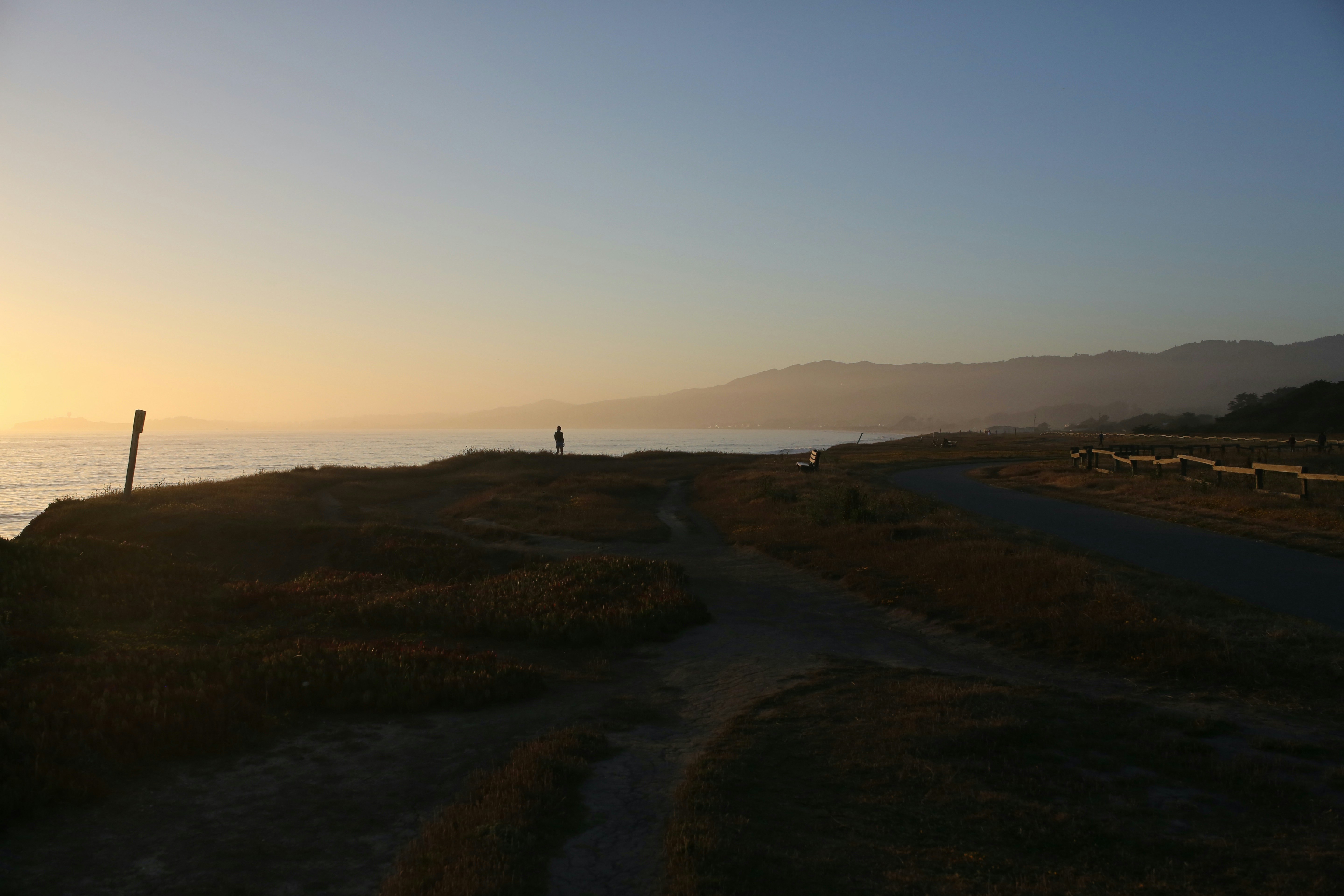 Dawn at the Cliff Path: A Lone Figure Against the Sea