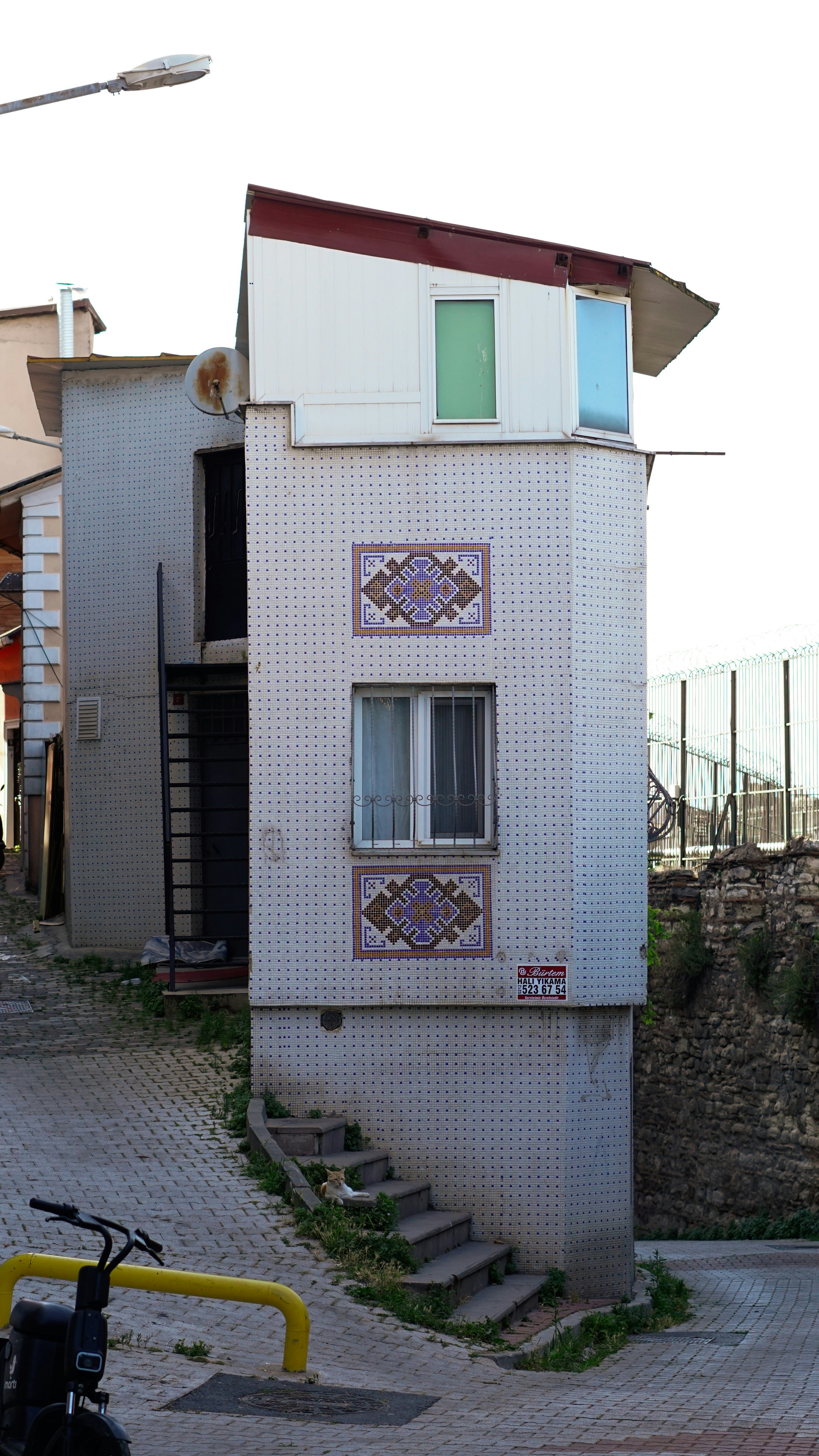 Mosaic Facade Over a Narrow Staircase: An Odd Urban House