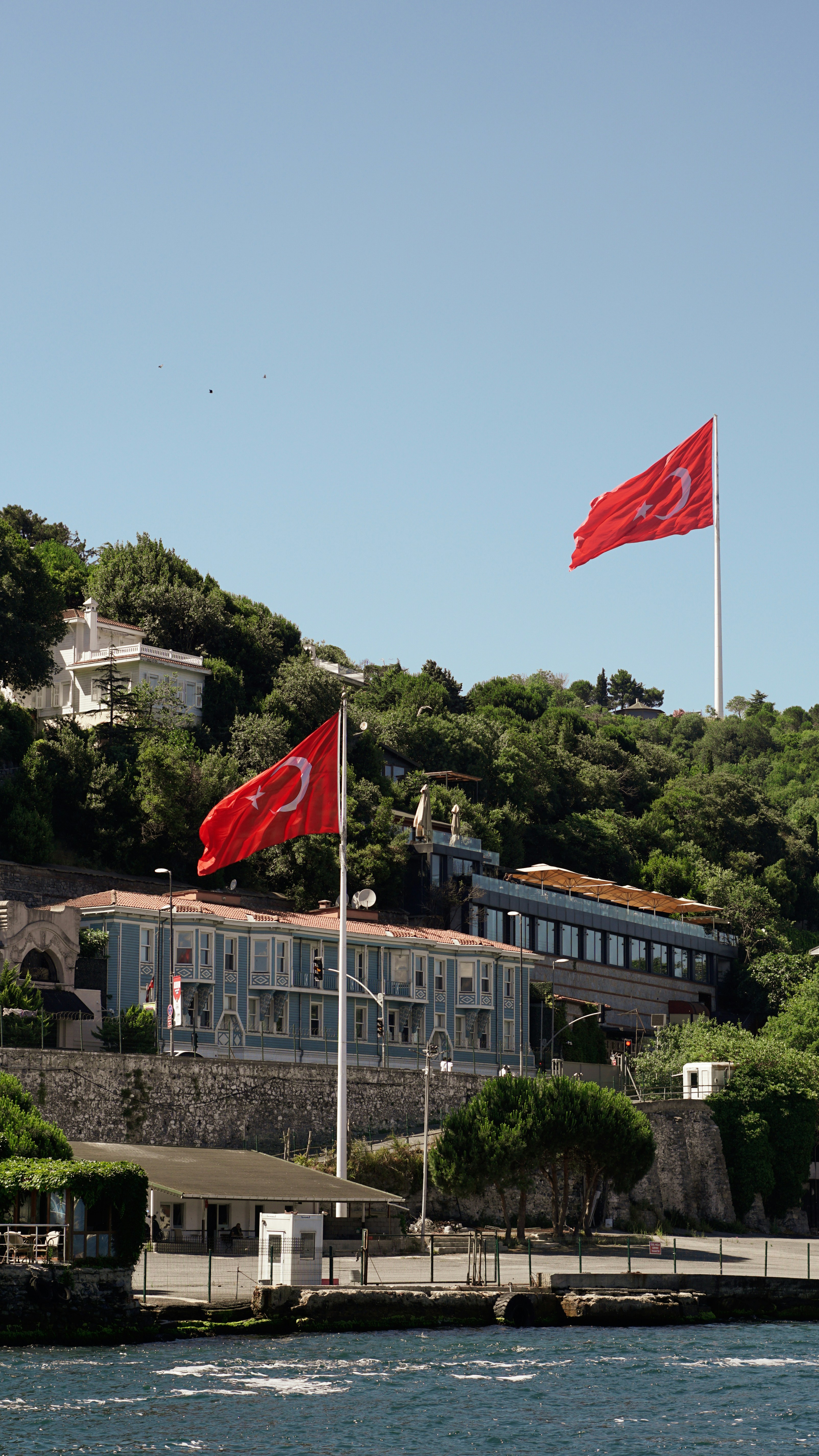 Scarlet Flags Over a Turquoise Coastal Village