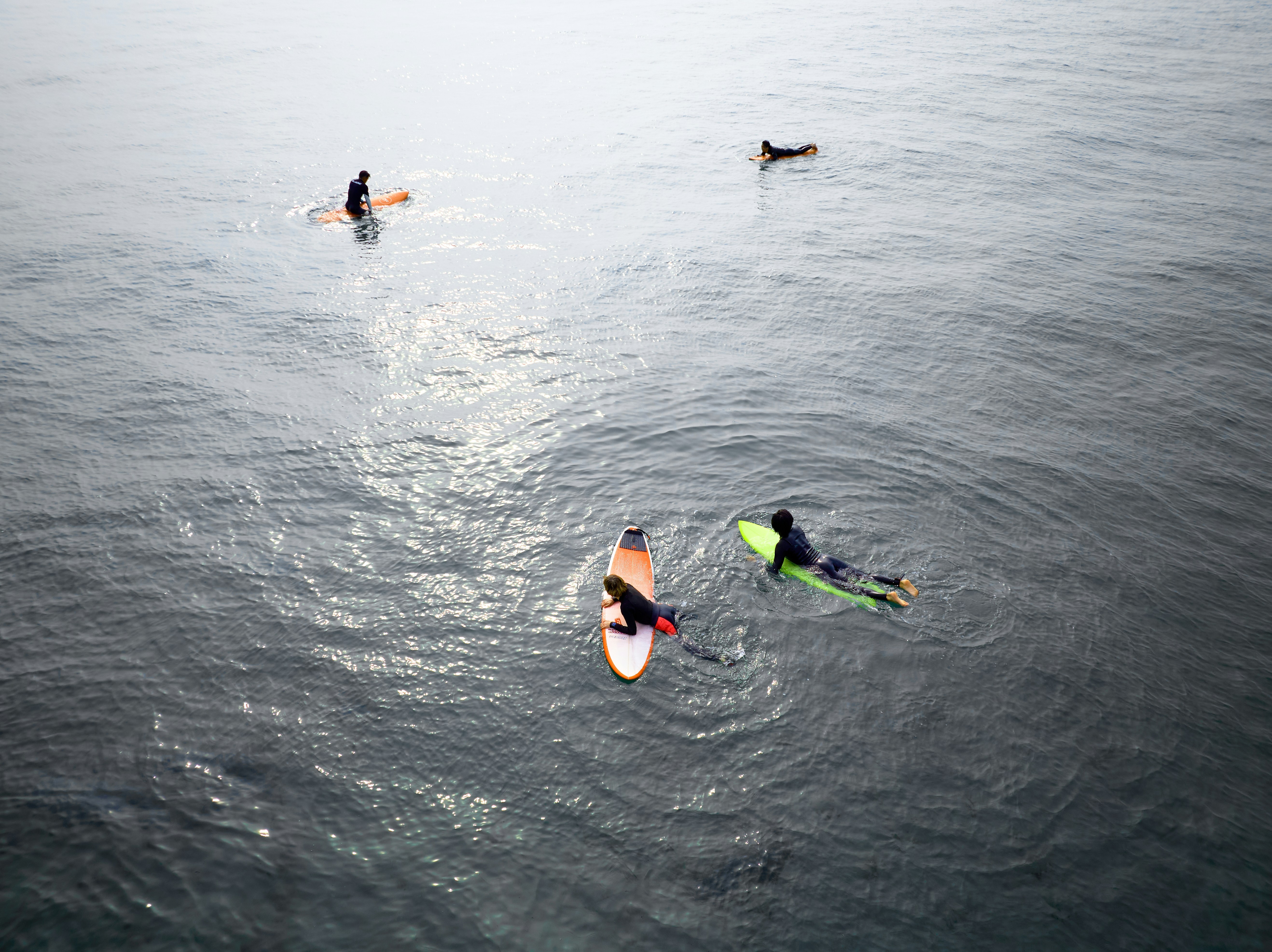 A group of people riding surfboards on top of a body of water photo ...