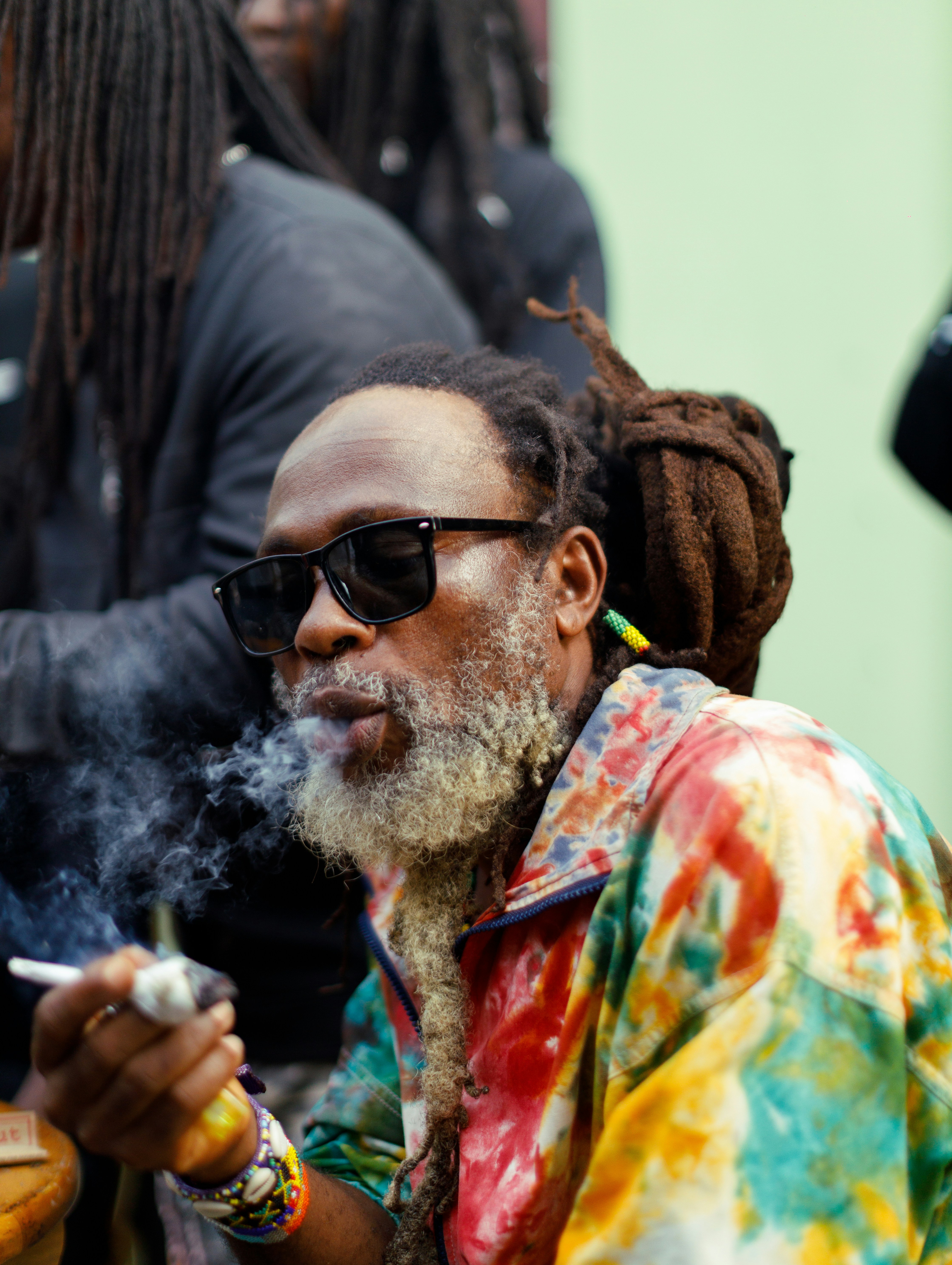 A man with dreadlocks smoking a cigarette photo – Free Man Image on ...