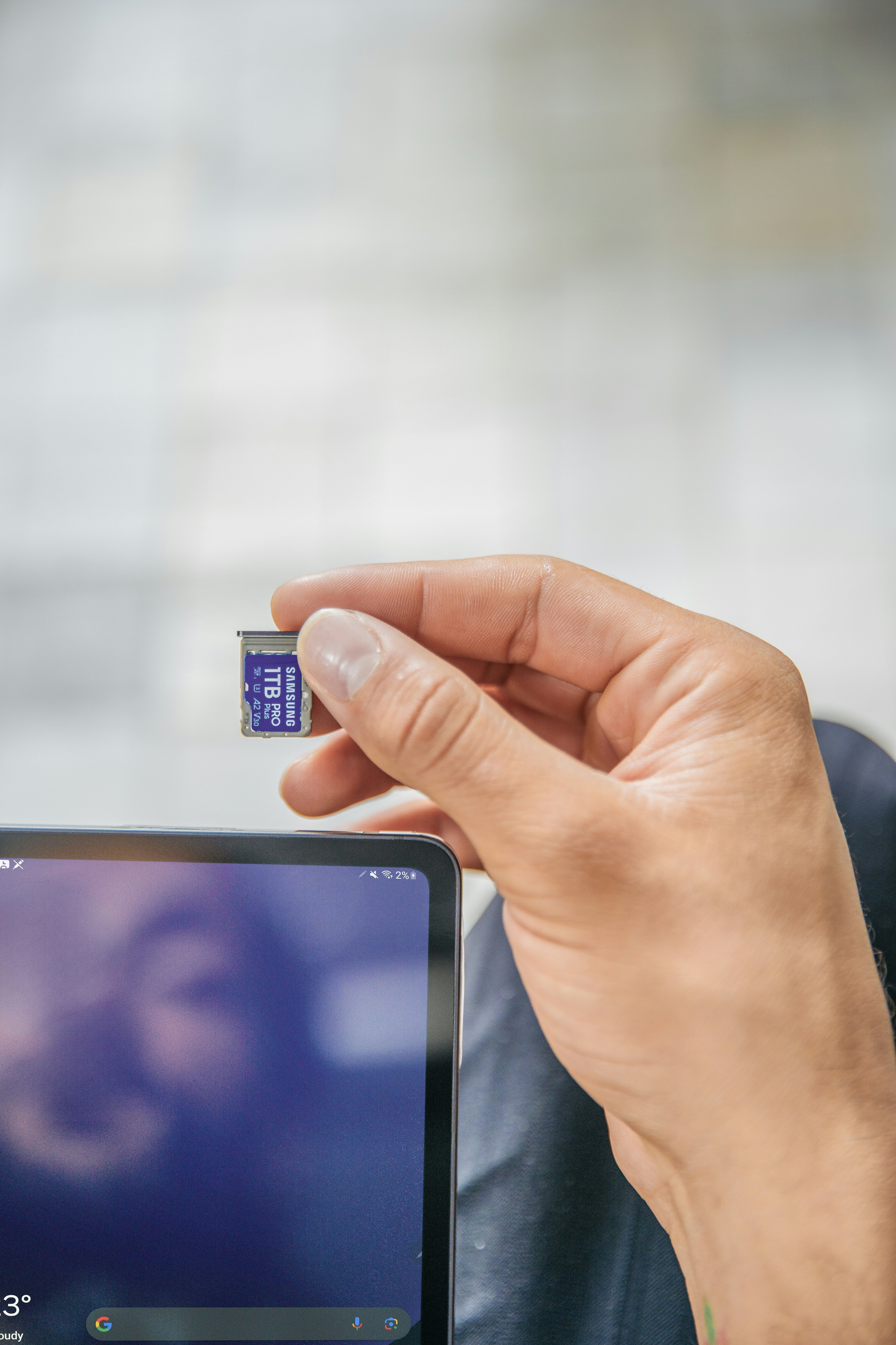 A person holding a small micro device in their hand photo – Free ...