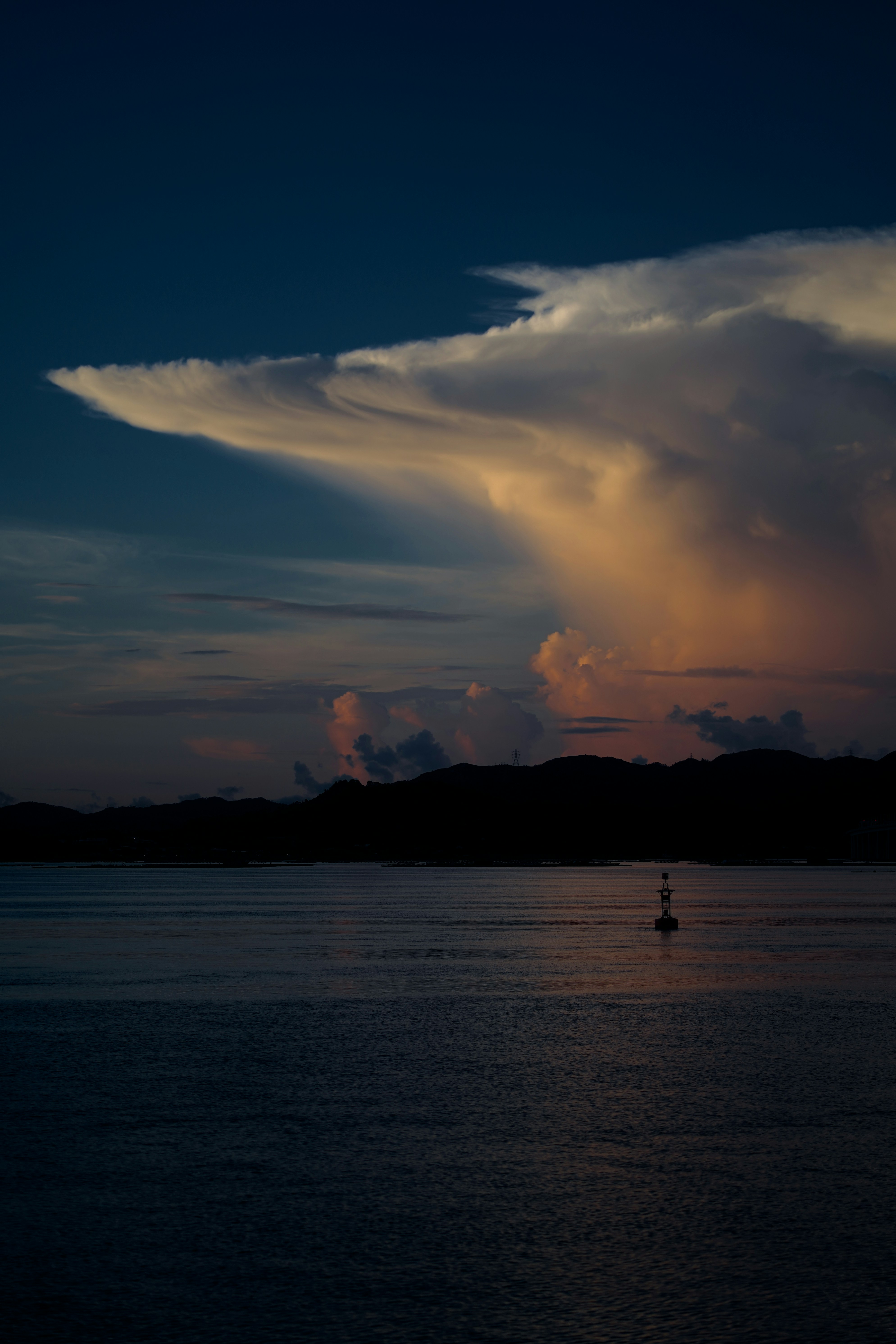 Last Light over the Calm: A Sailor's Silhouette Beneath a Cloud-Worn Sky