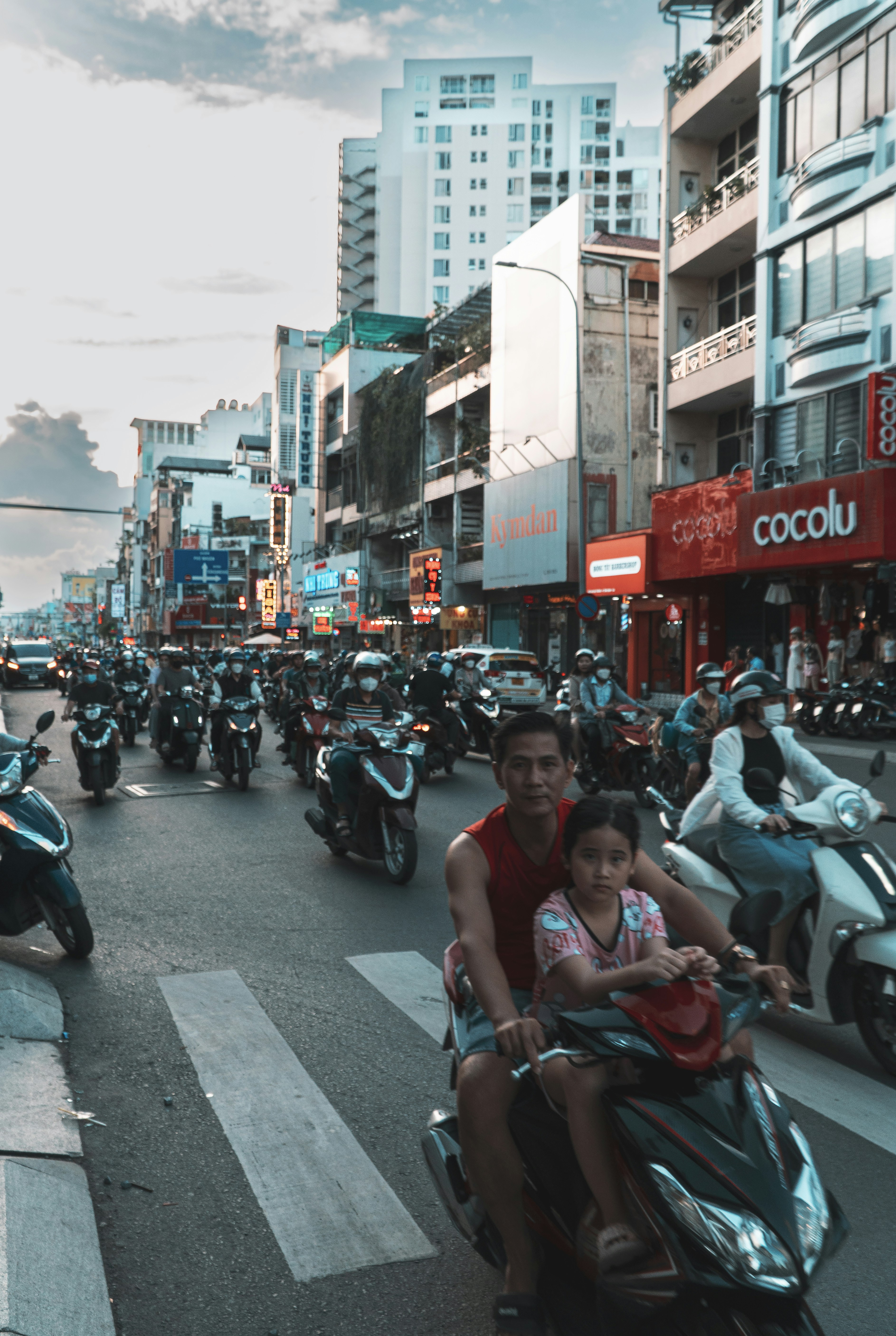 A group of people riding scooters down a street photo – Free Ho chi ...