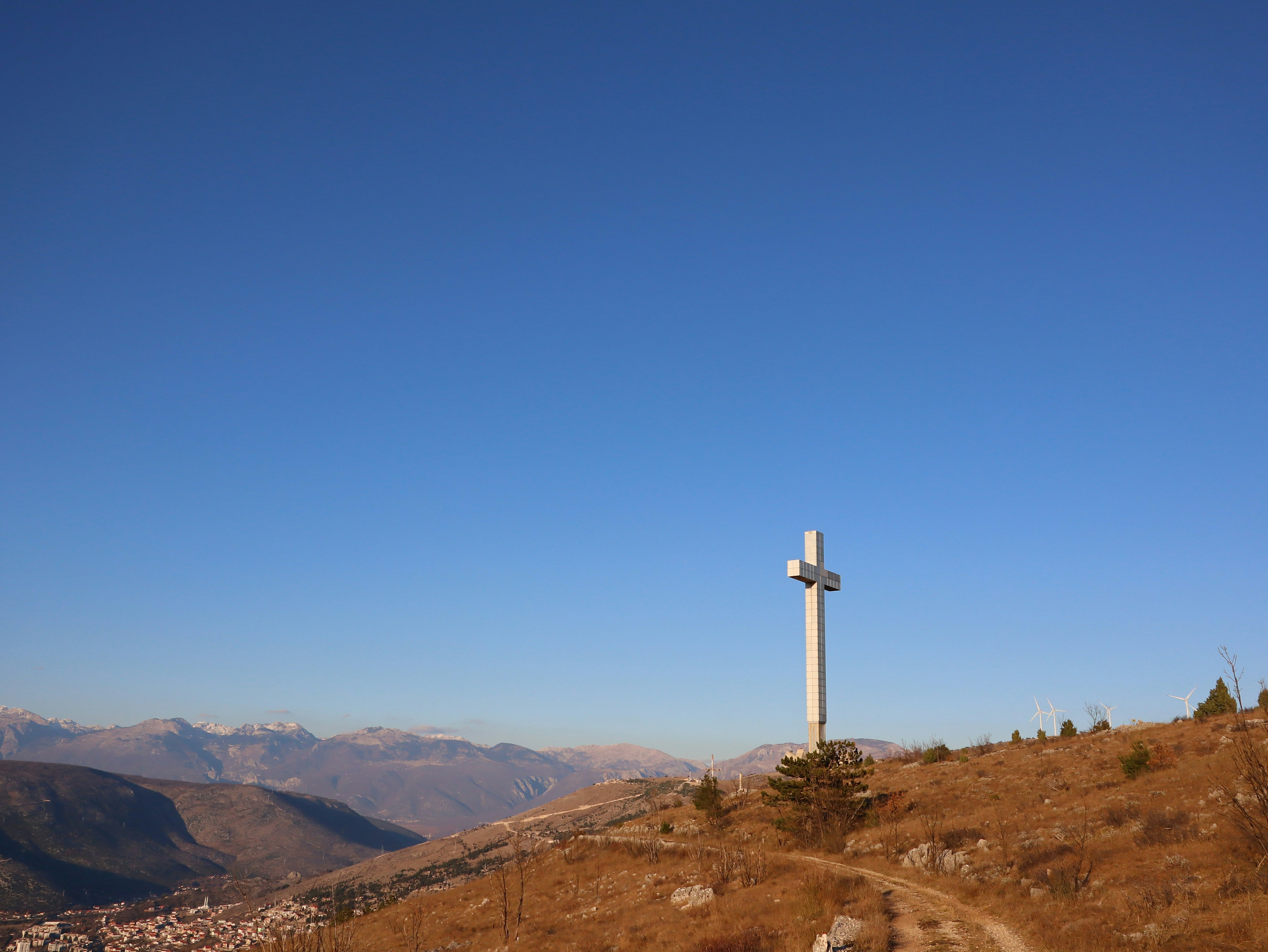 A cross on a hill overlooking a citymonk 333