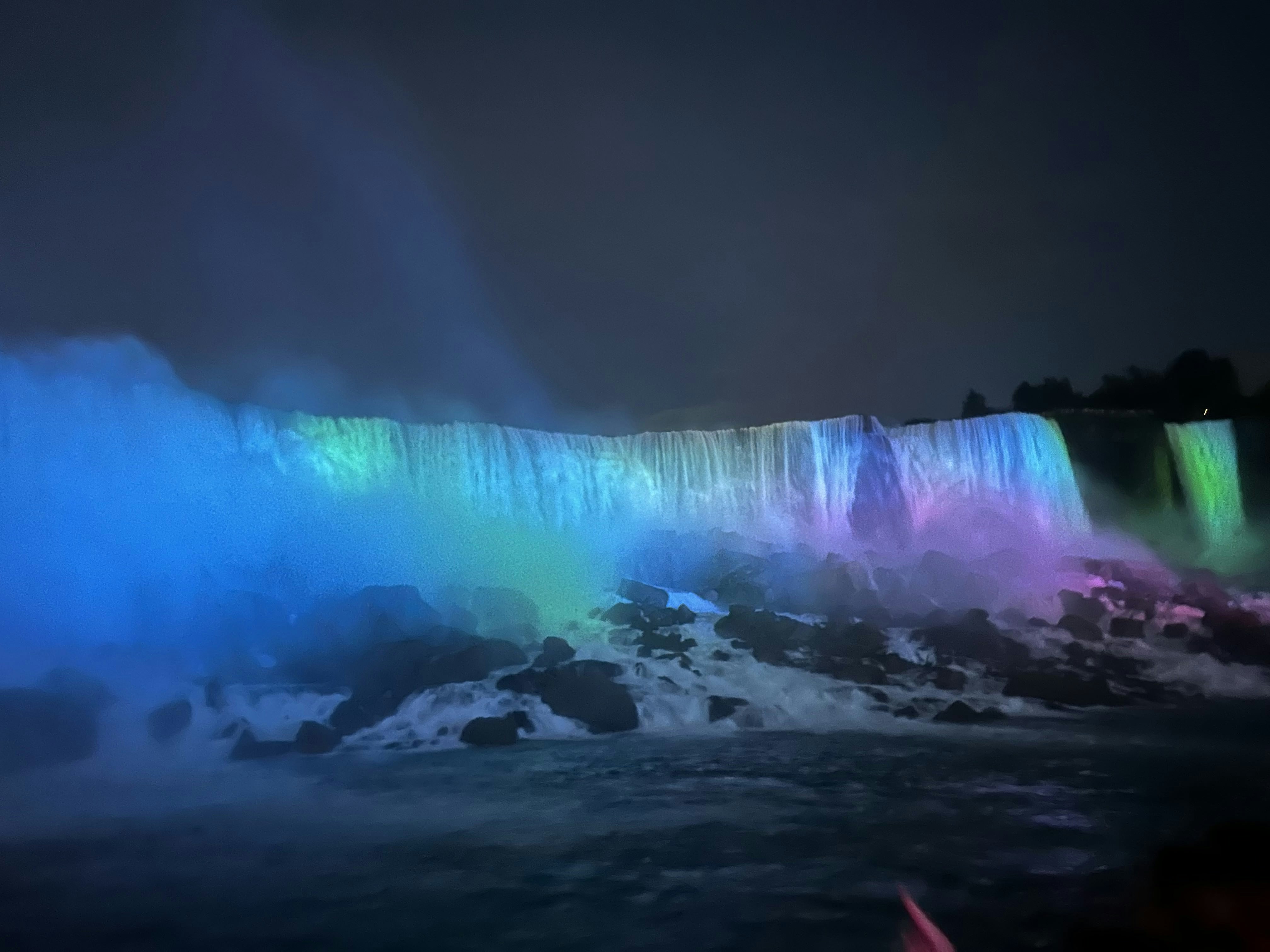 A rainbow waterfall is lit up at night photo – Free Sea Image on Unsplash