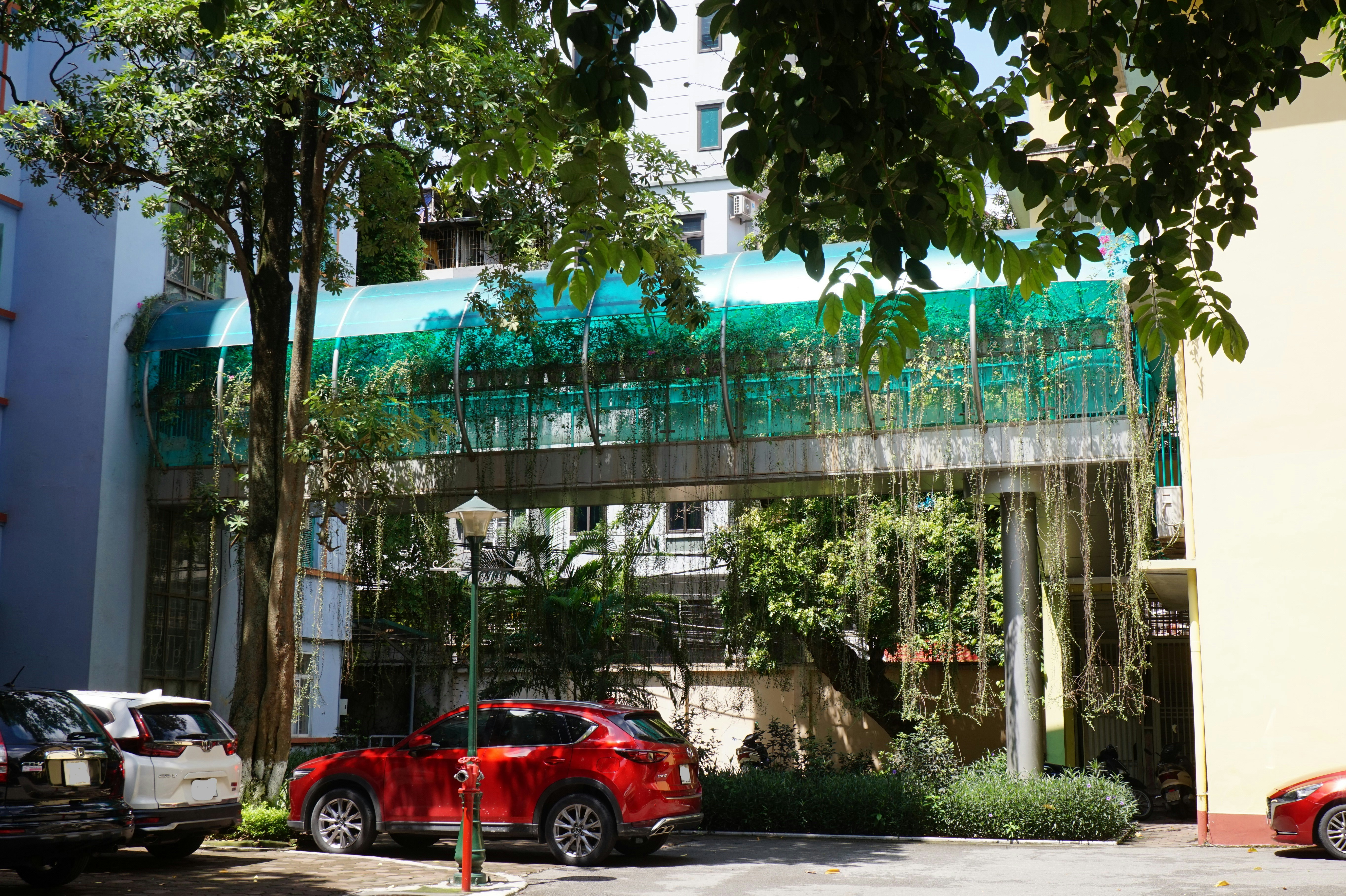 A red car is parked in front of a building photo – Free Car Image on ...