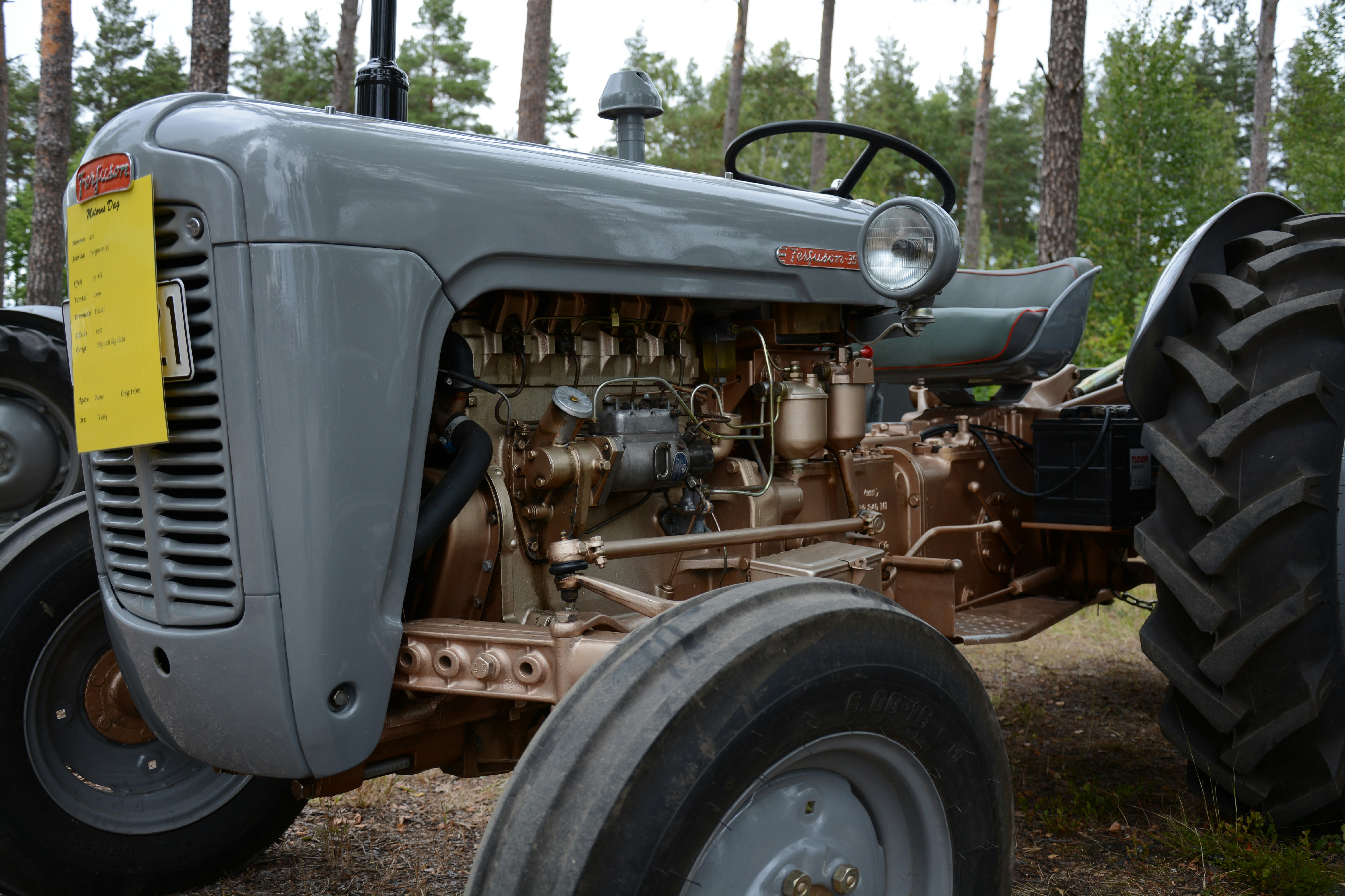 A gray tractor parked on top of a grass covered field photo – Free Grey ...