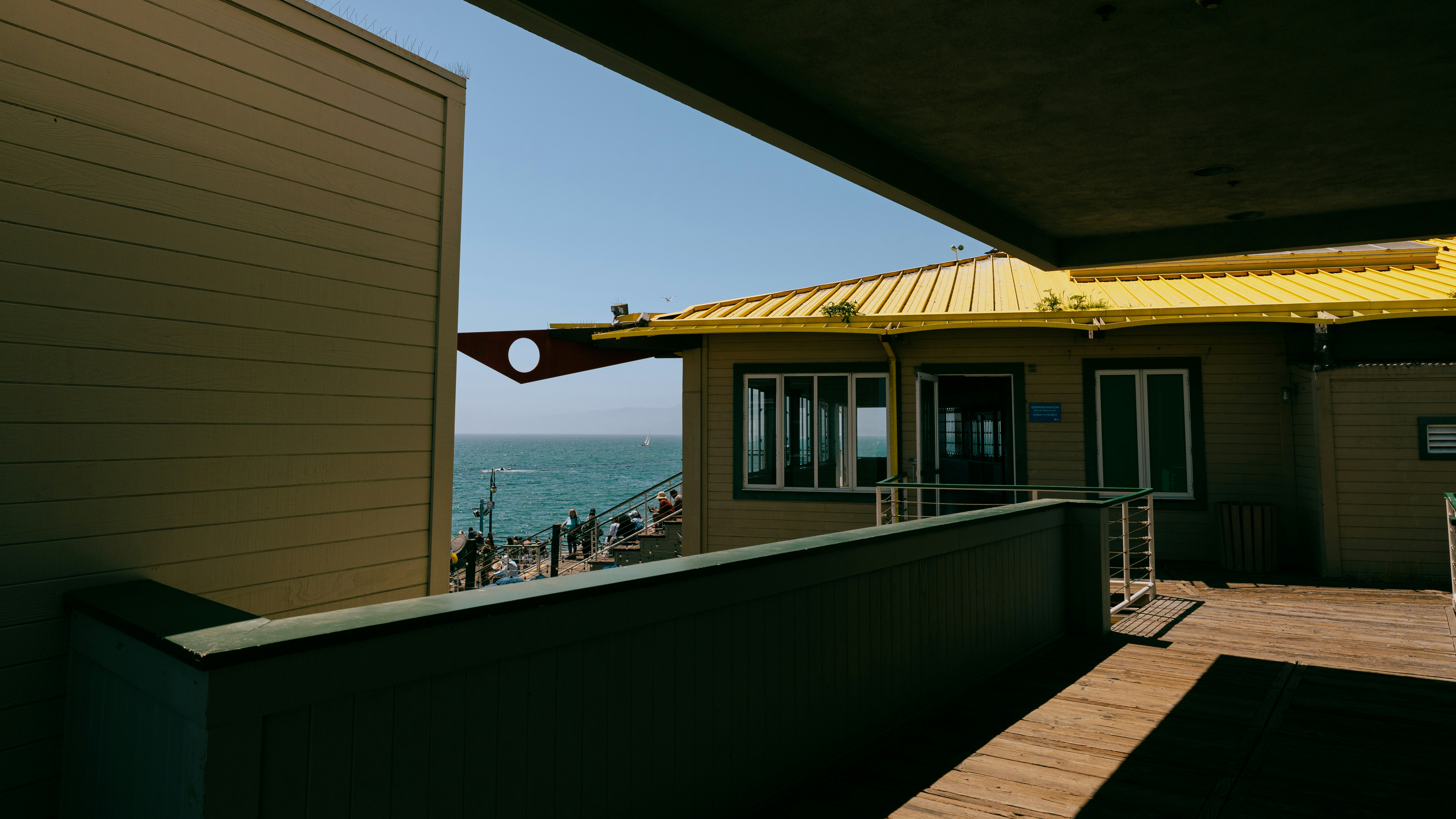 Sunlit Seaside Passage: Golden Facades Framing the Ocean