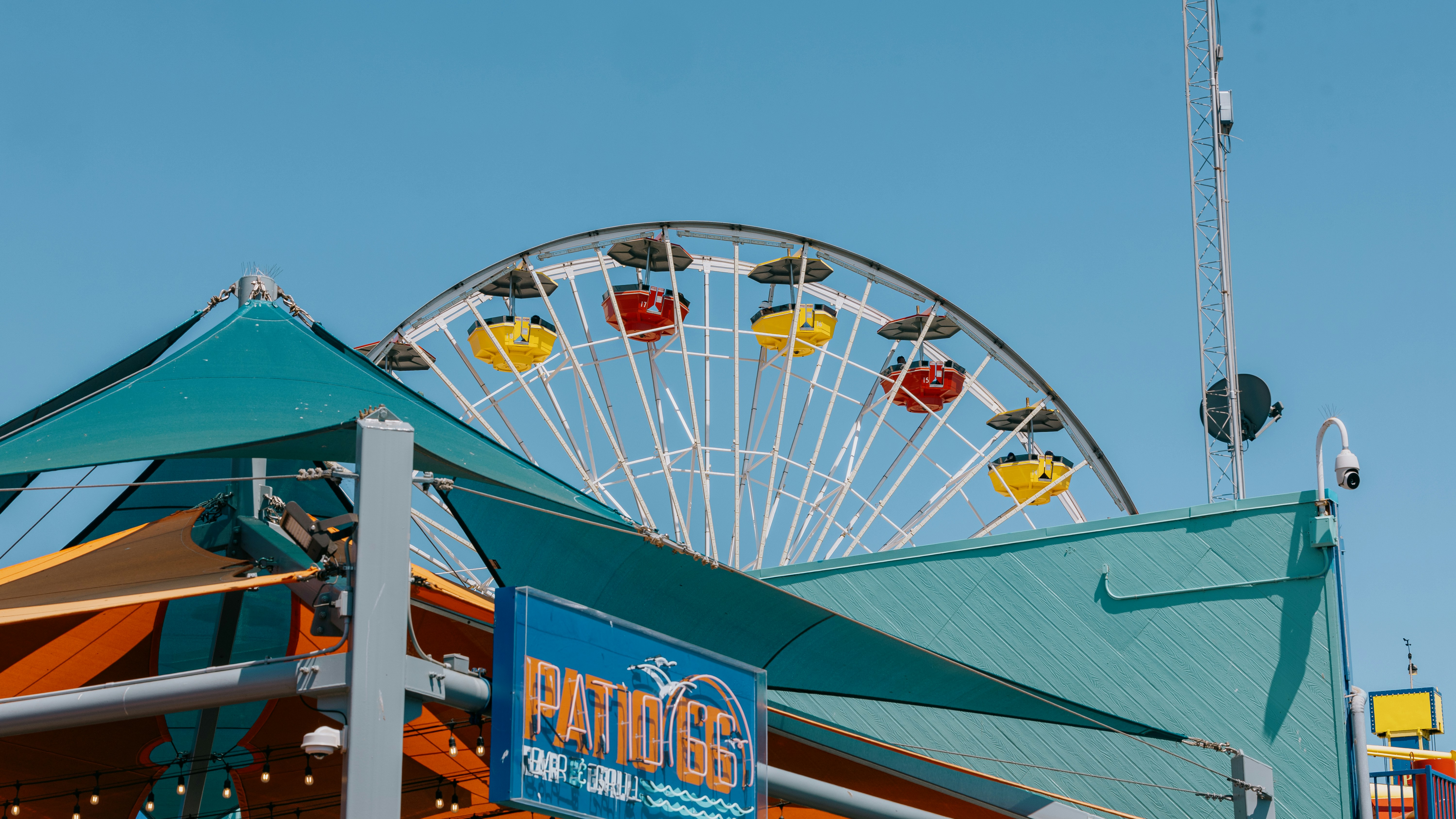 Ferris Wheel Crowned by Teal Canopies: A Sunlit Carnival Moment