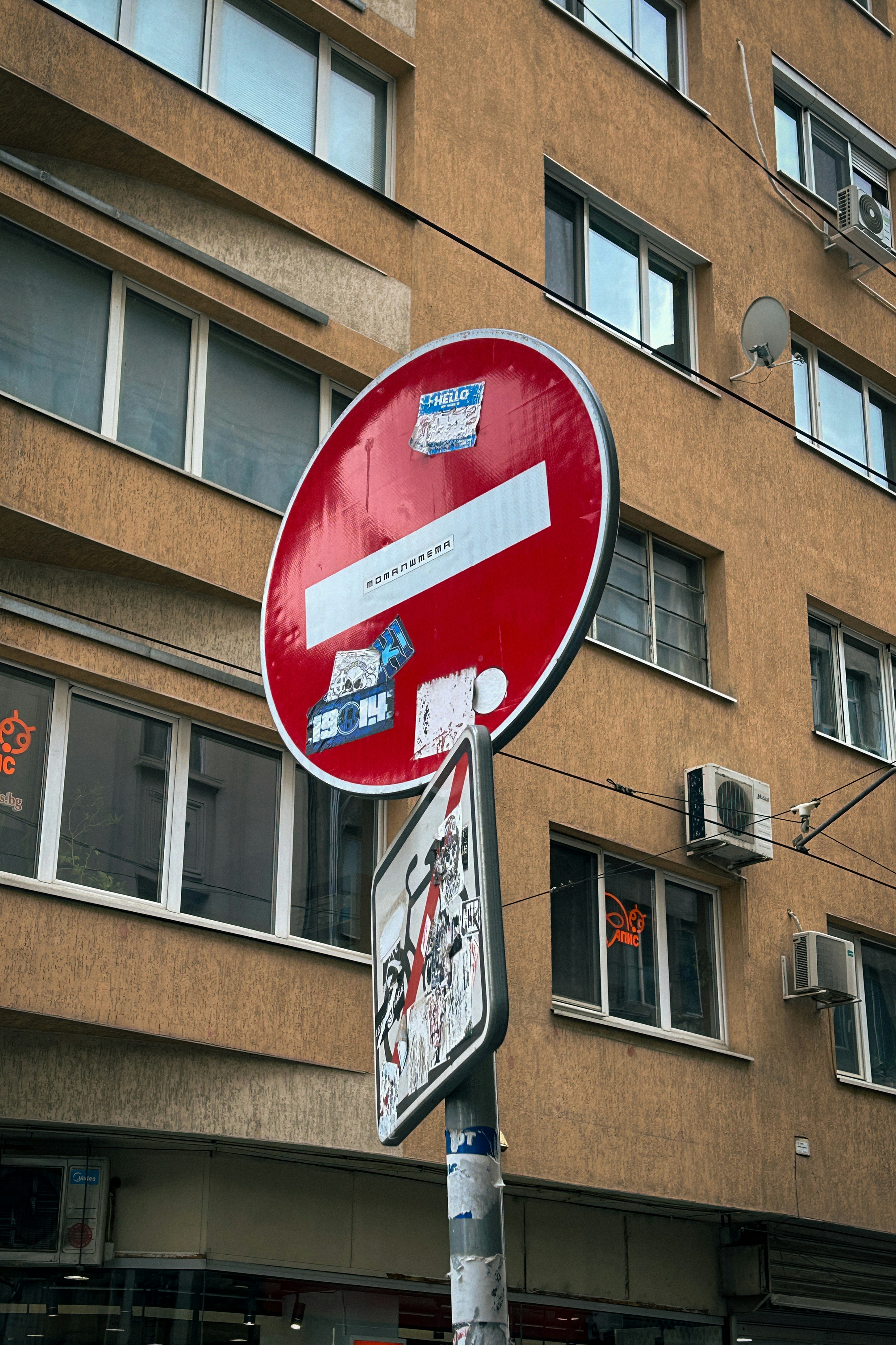 A red street sign sitting in front of a tall building photo – Free ...