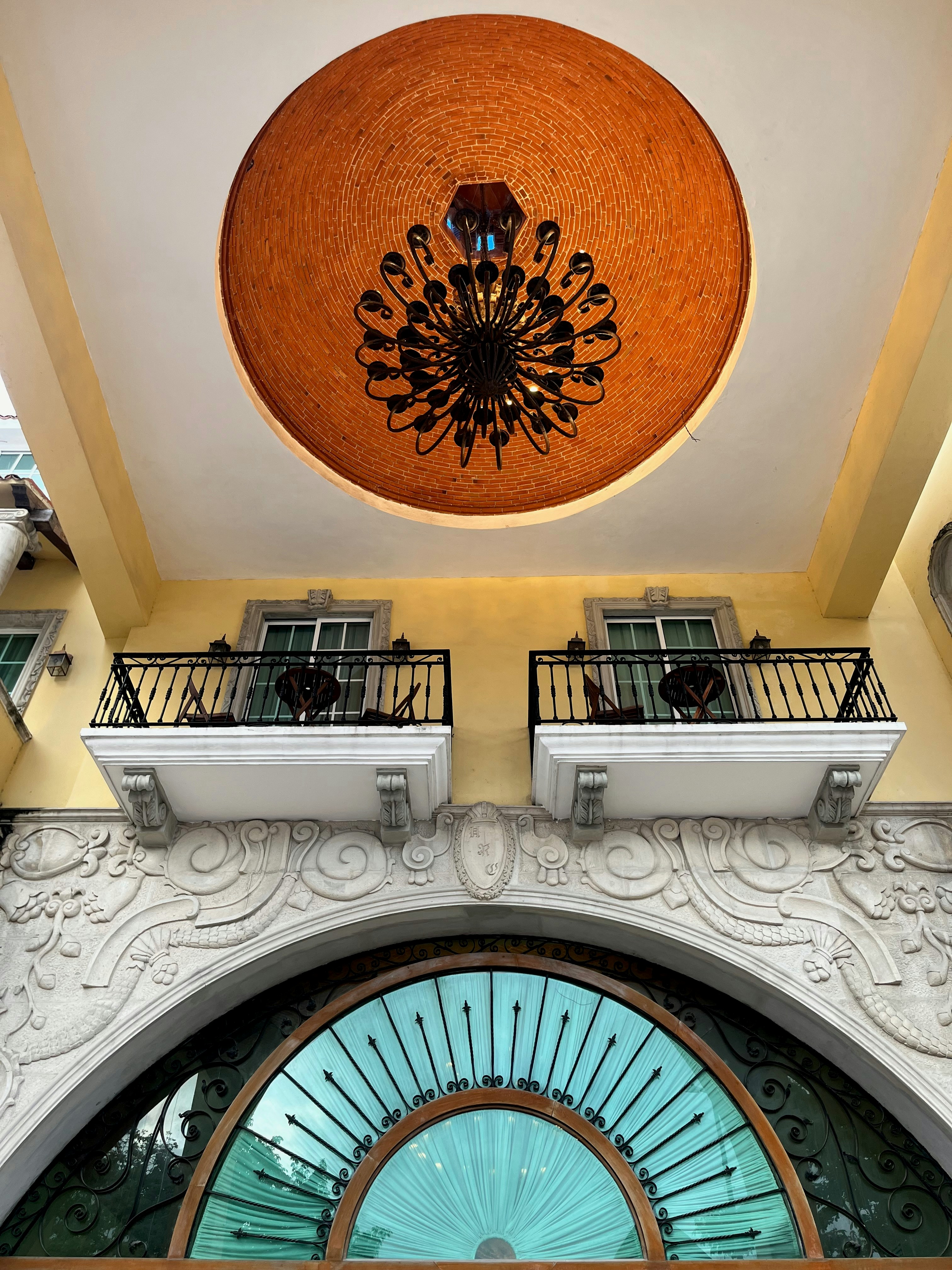 Amber Rotunda Lantern Crowned by Ironwork over a Turquoise Arch
