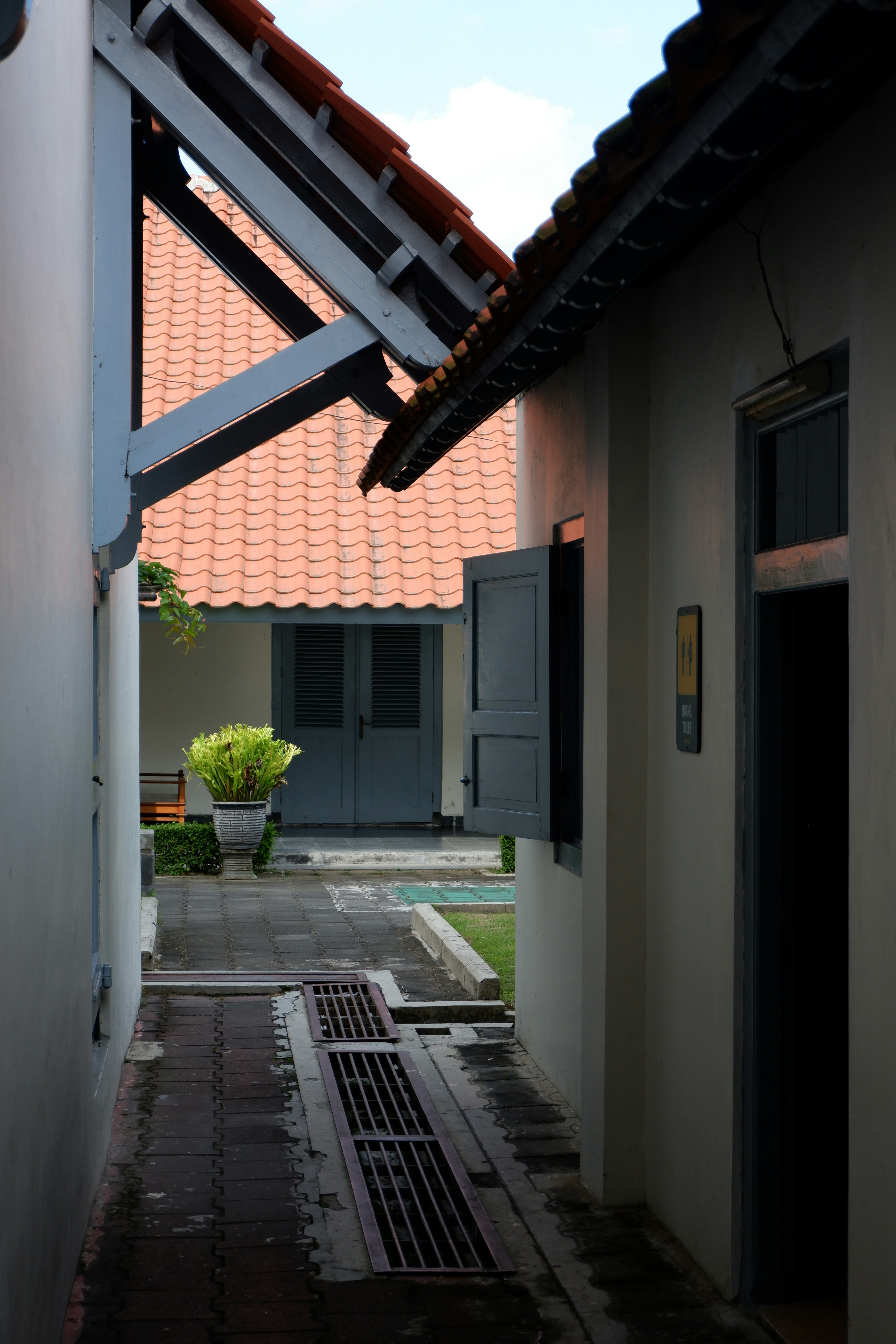 Between Shade and Tile: A Narrow Corridor Framing a Sunlit Courtyard