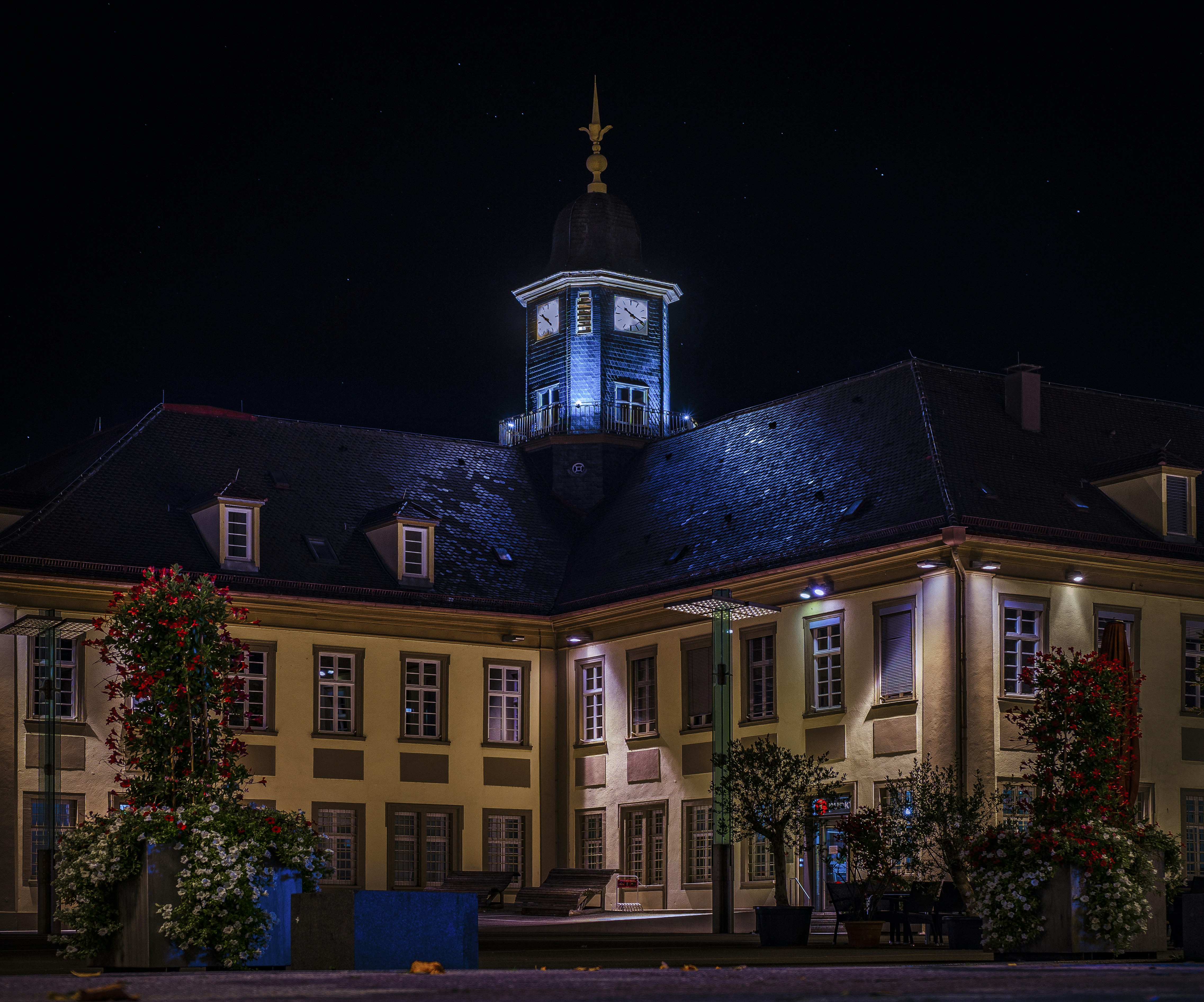 Illuminated historic building with a central tower against a night sky.