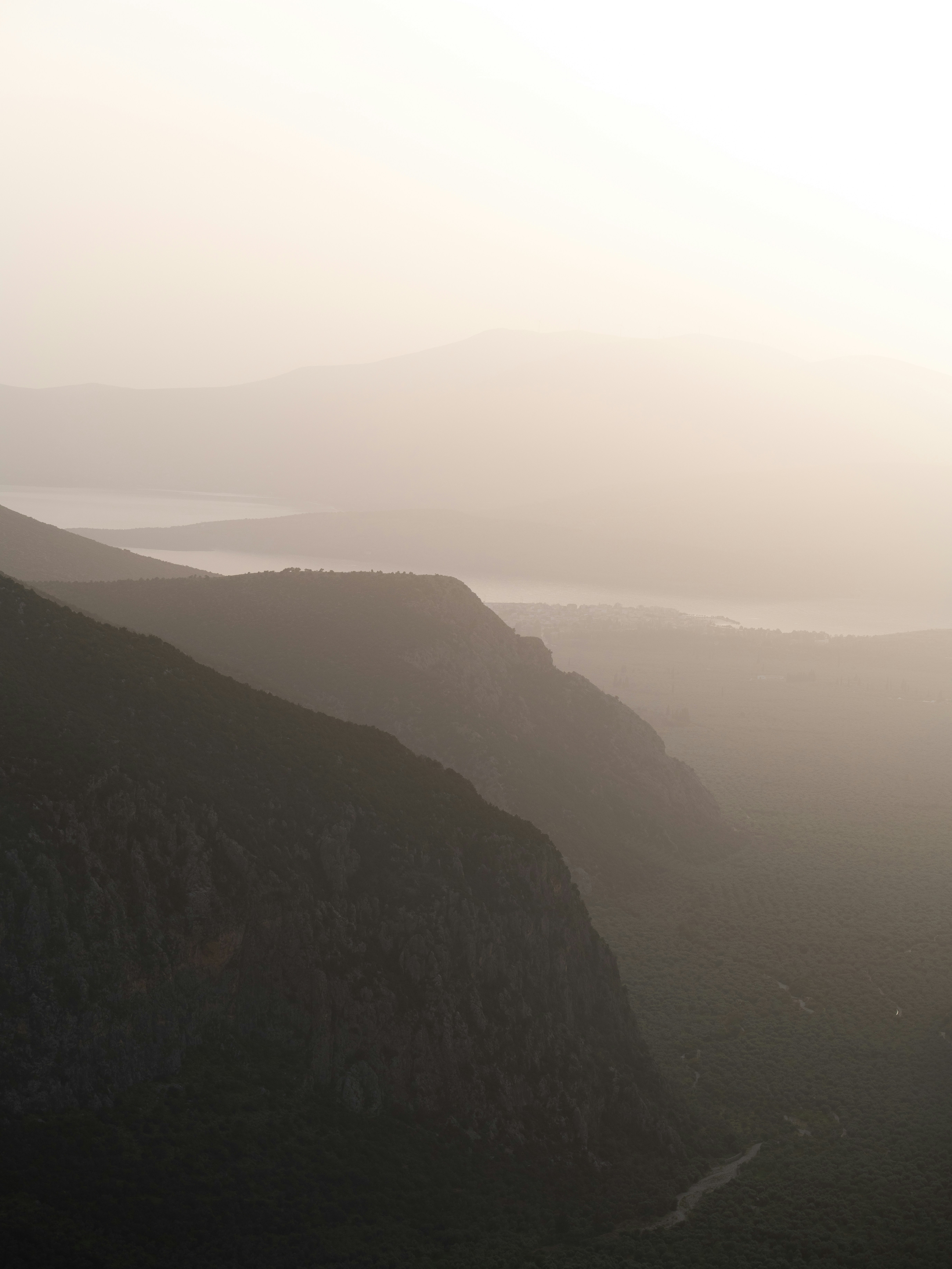 A person standing on a cliff overlooking a body of water photo – Free ...
