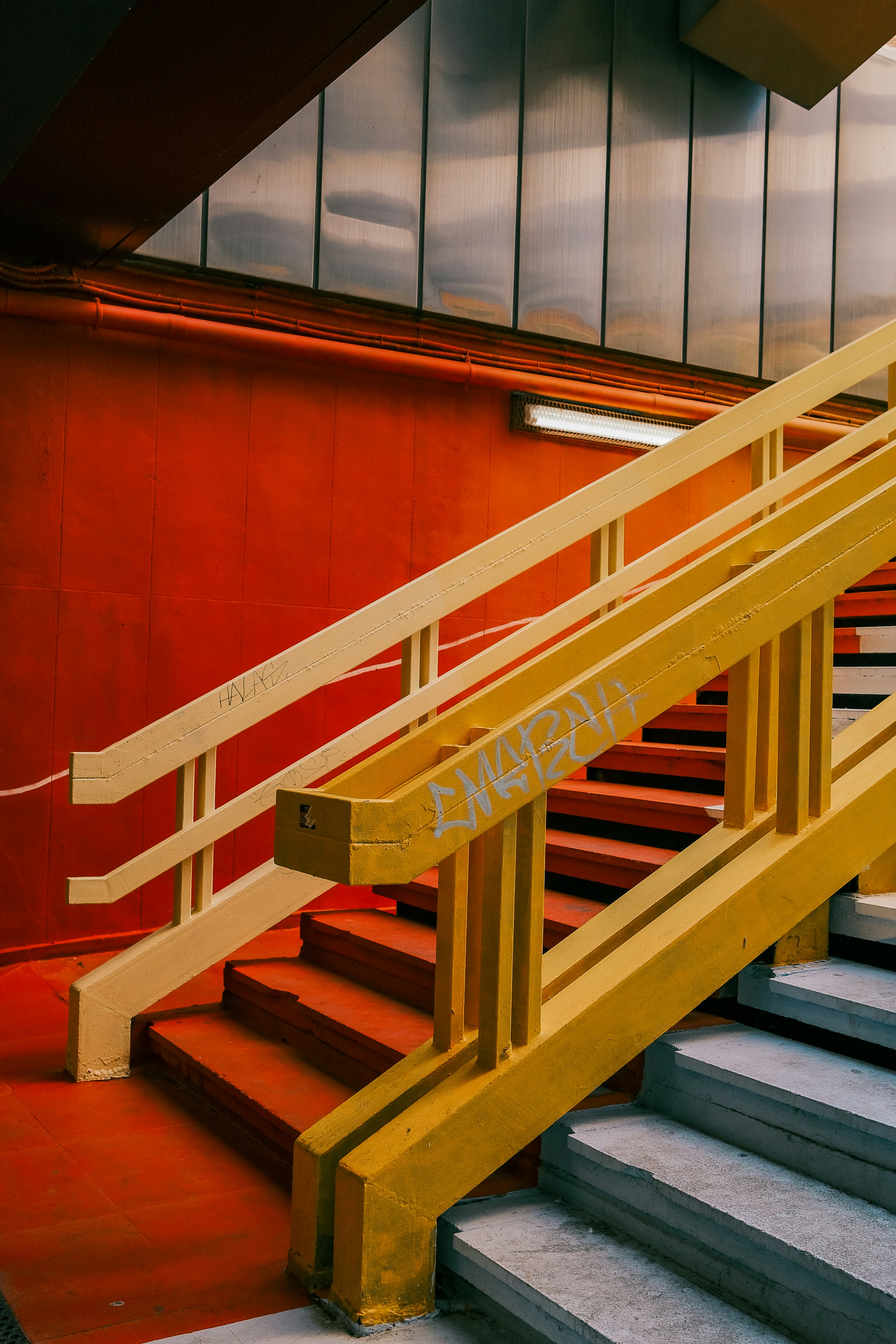 Amber Rails Crossing a Crimson Stairwell