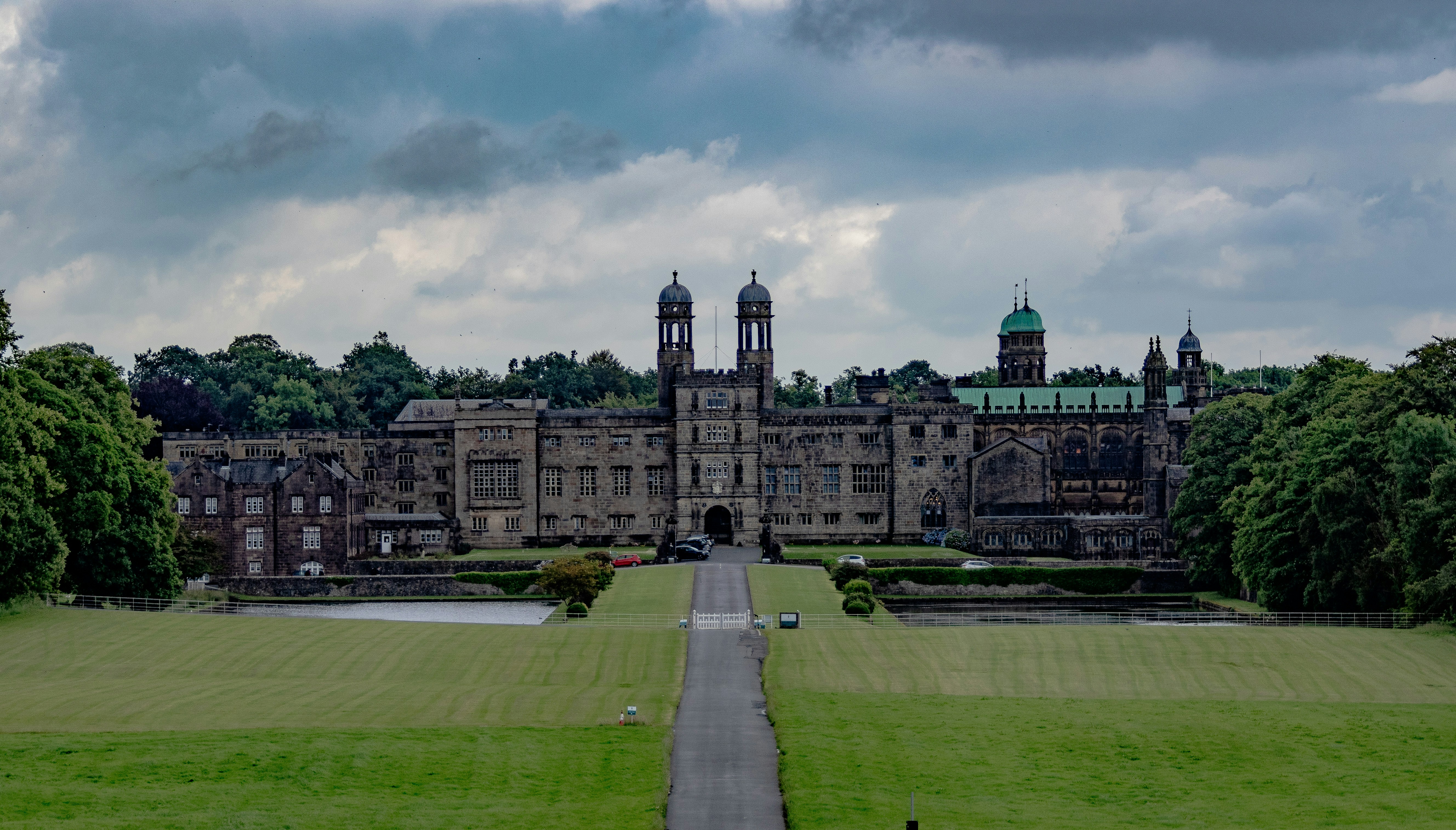 A large building sitting on top of a lush green field photo – Free ...