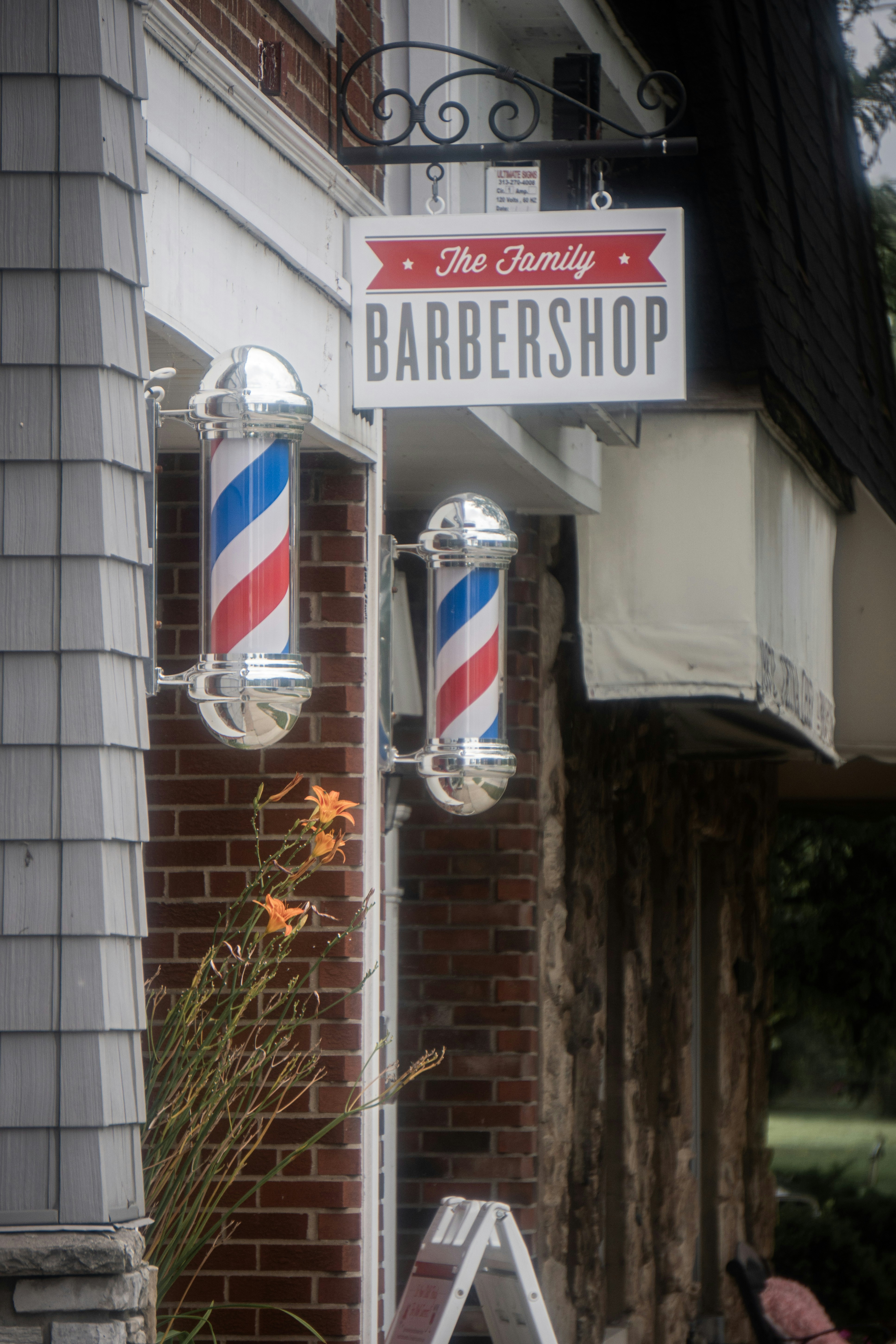 The Family Barbershop Sign Framed by Classic Striped Poles