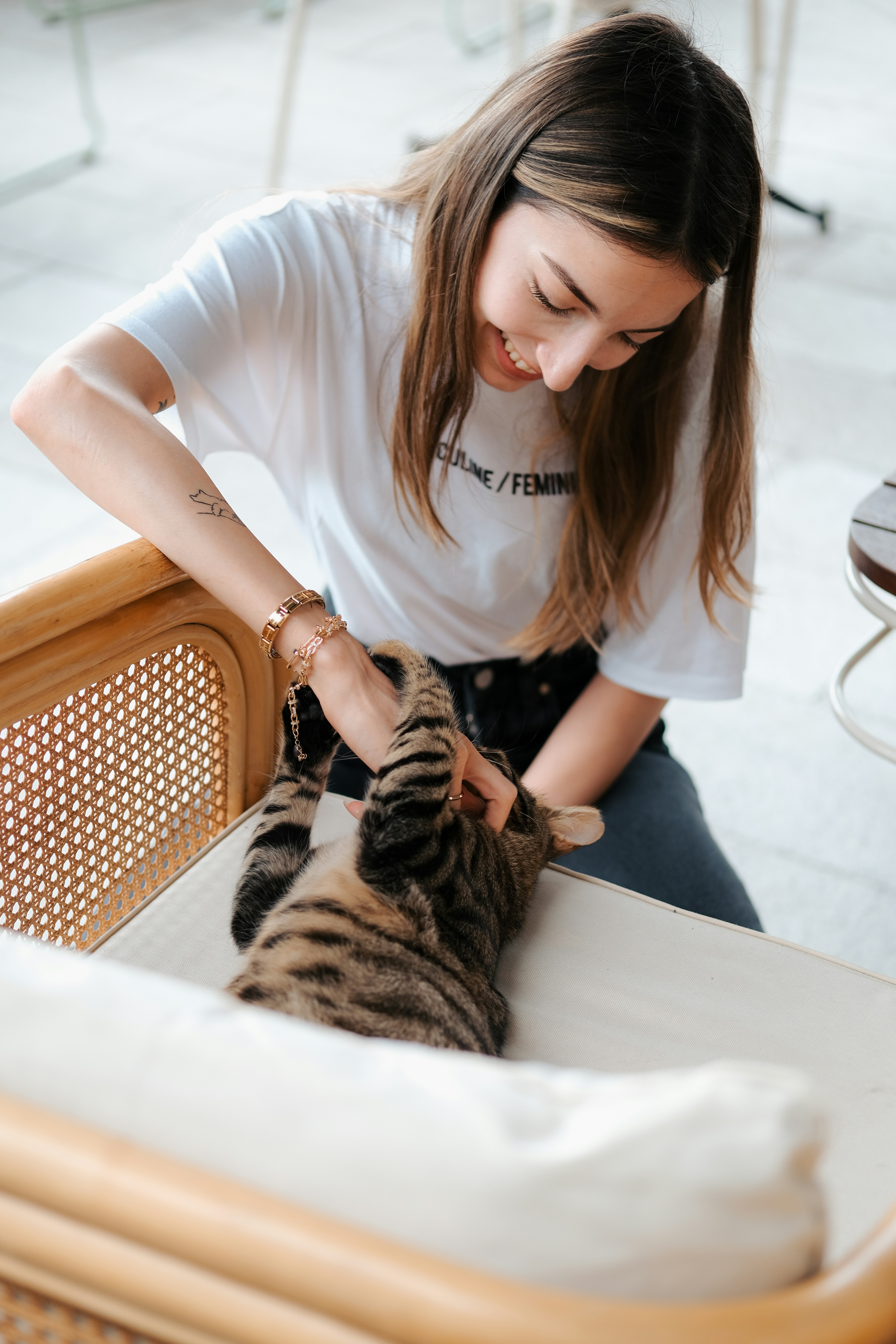A woman petting a cat in a wicker basket