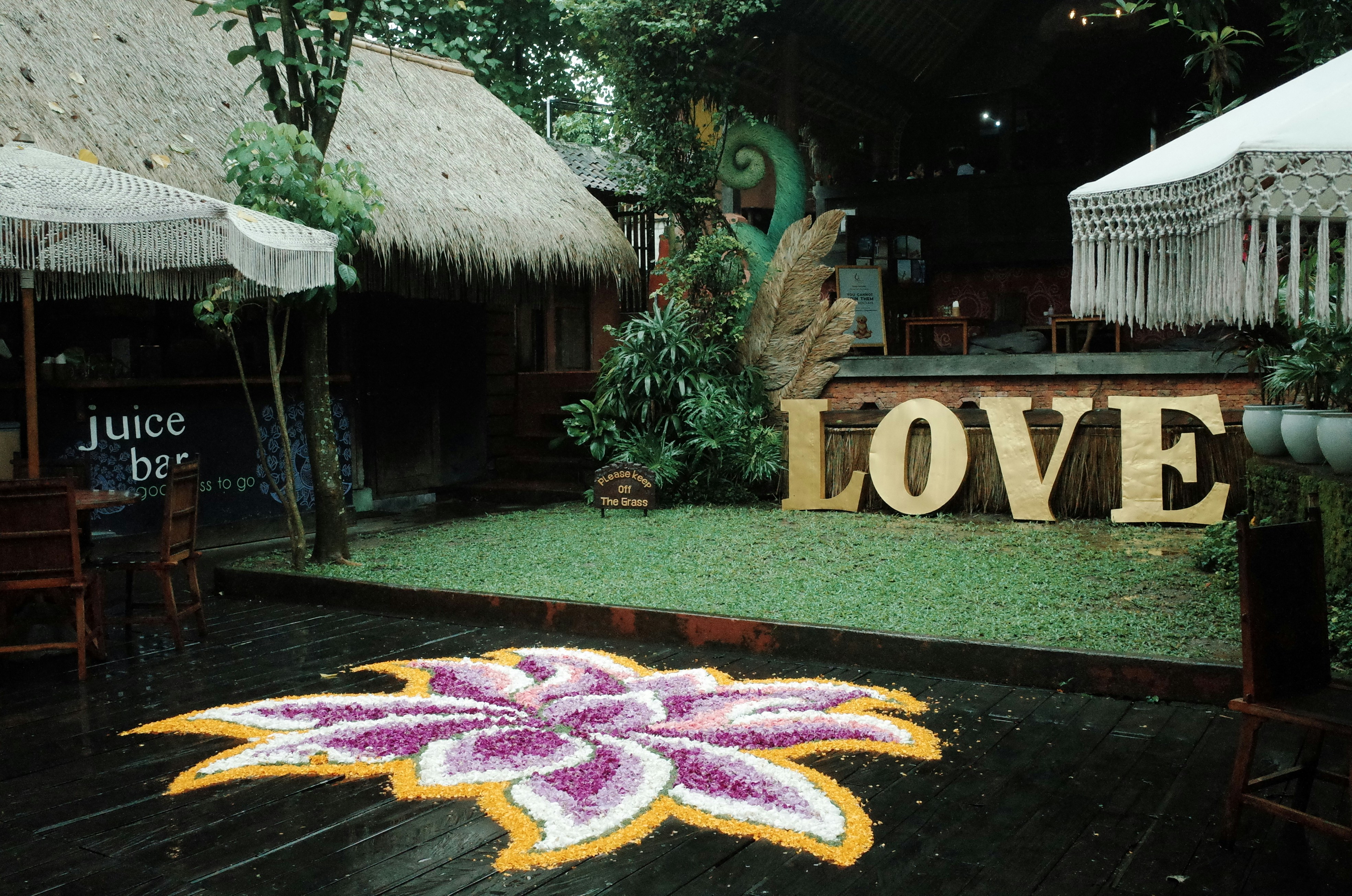 Rain-Wet Rangoli on a Wooden Deck Framed by Love