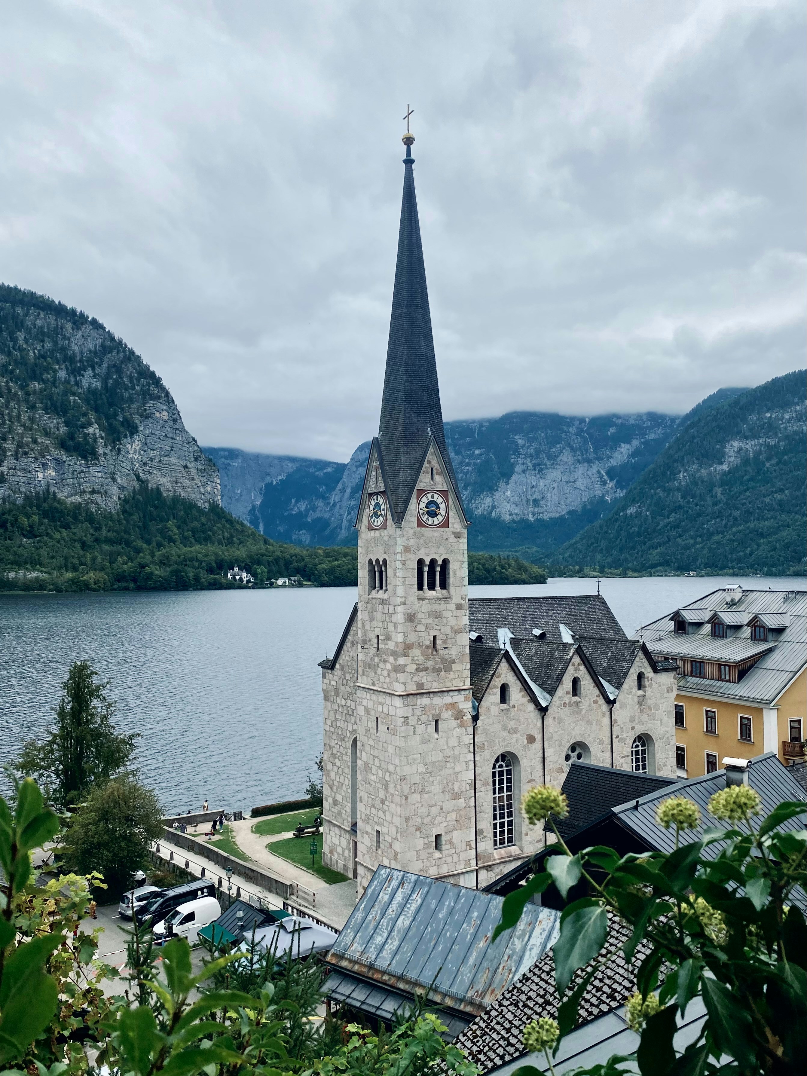 A church with a steeple next to a body of water photo – Free Austria ...