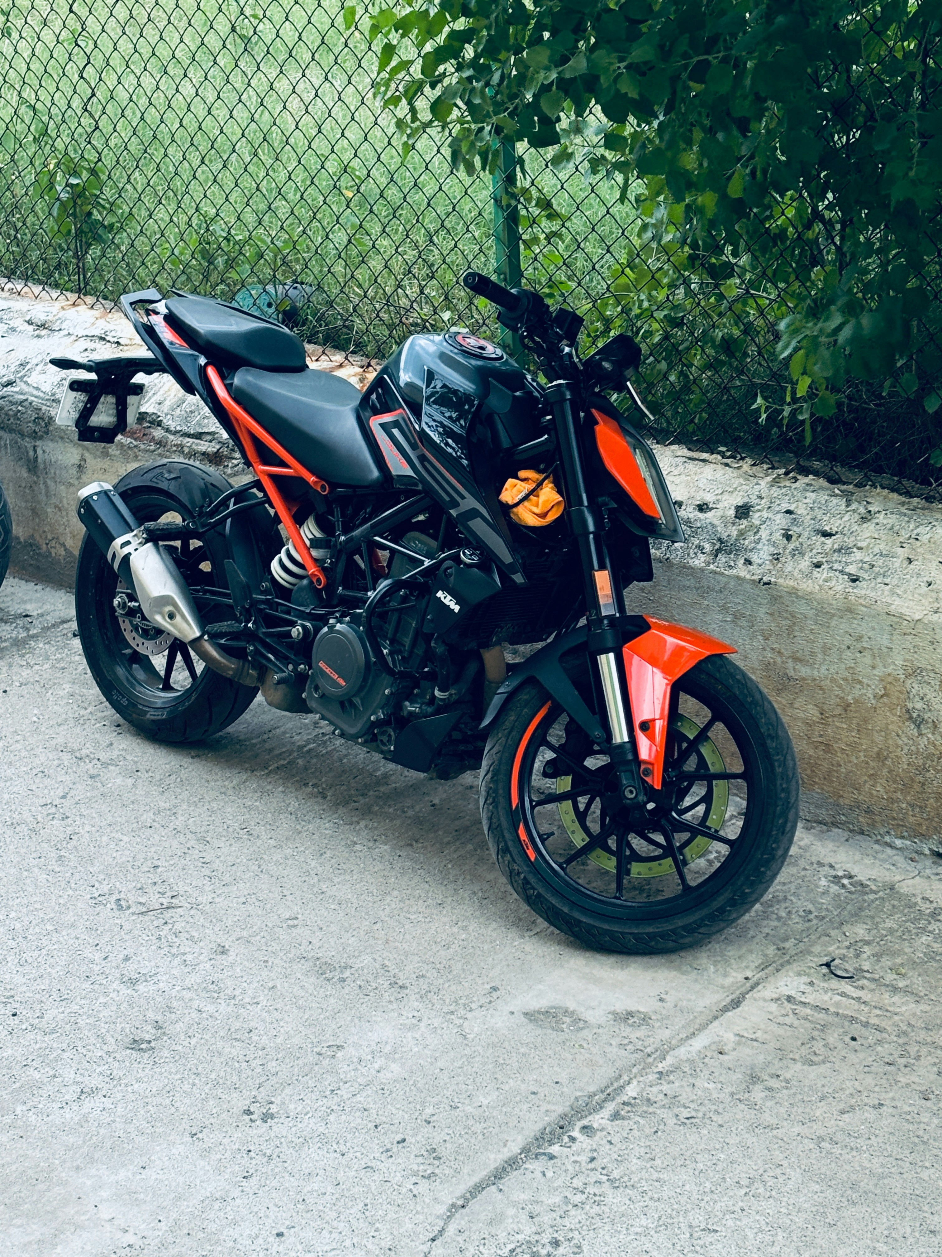 Orange-steel Stallion: A Stance-Ready Streetfighter by the Fence