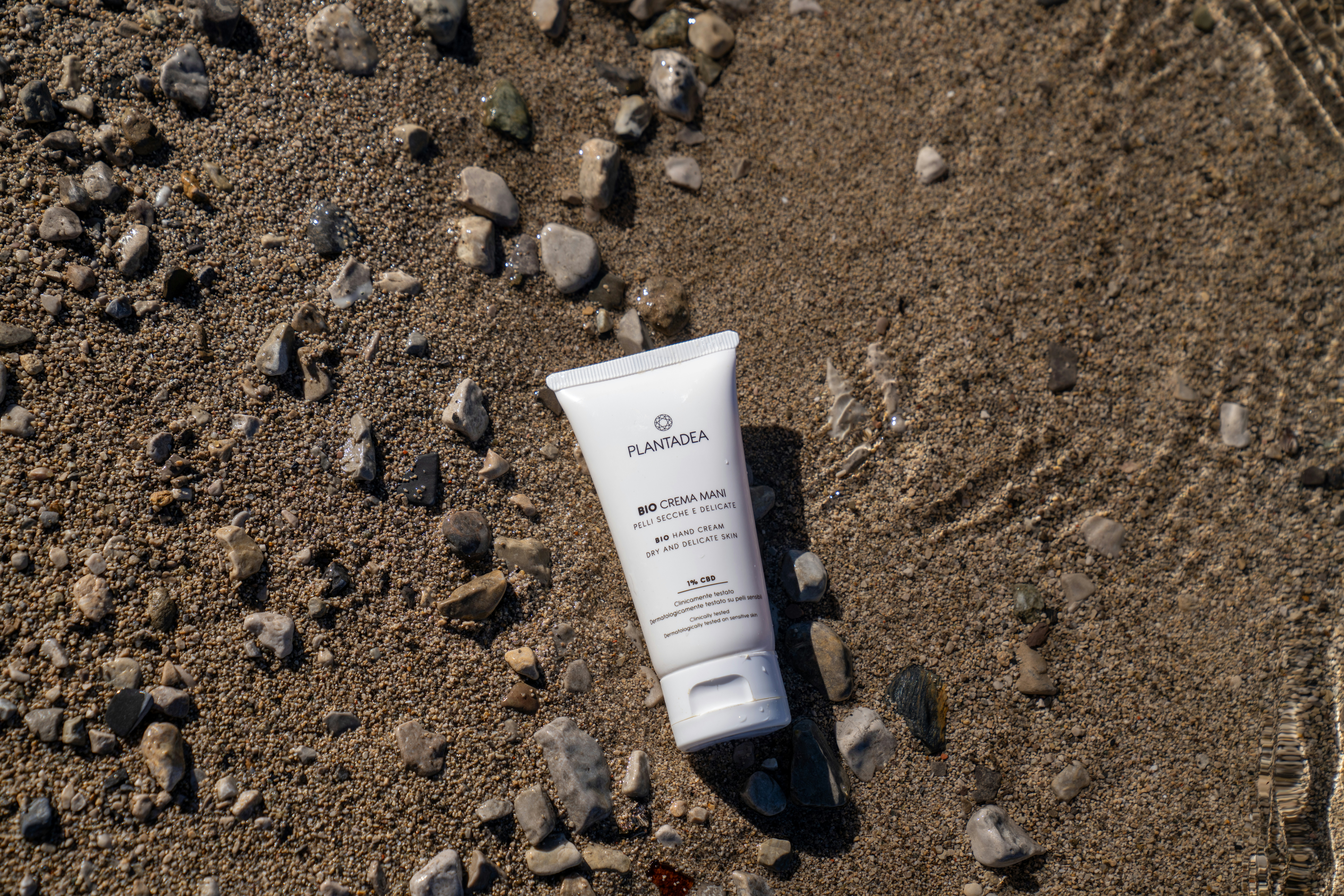 A tube of sunscreen sitting on the ground photo – Free Grey Image on ...