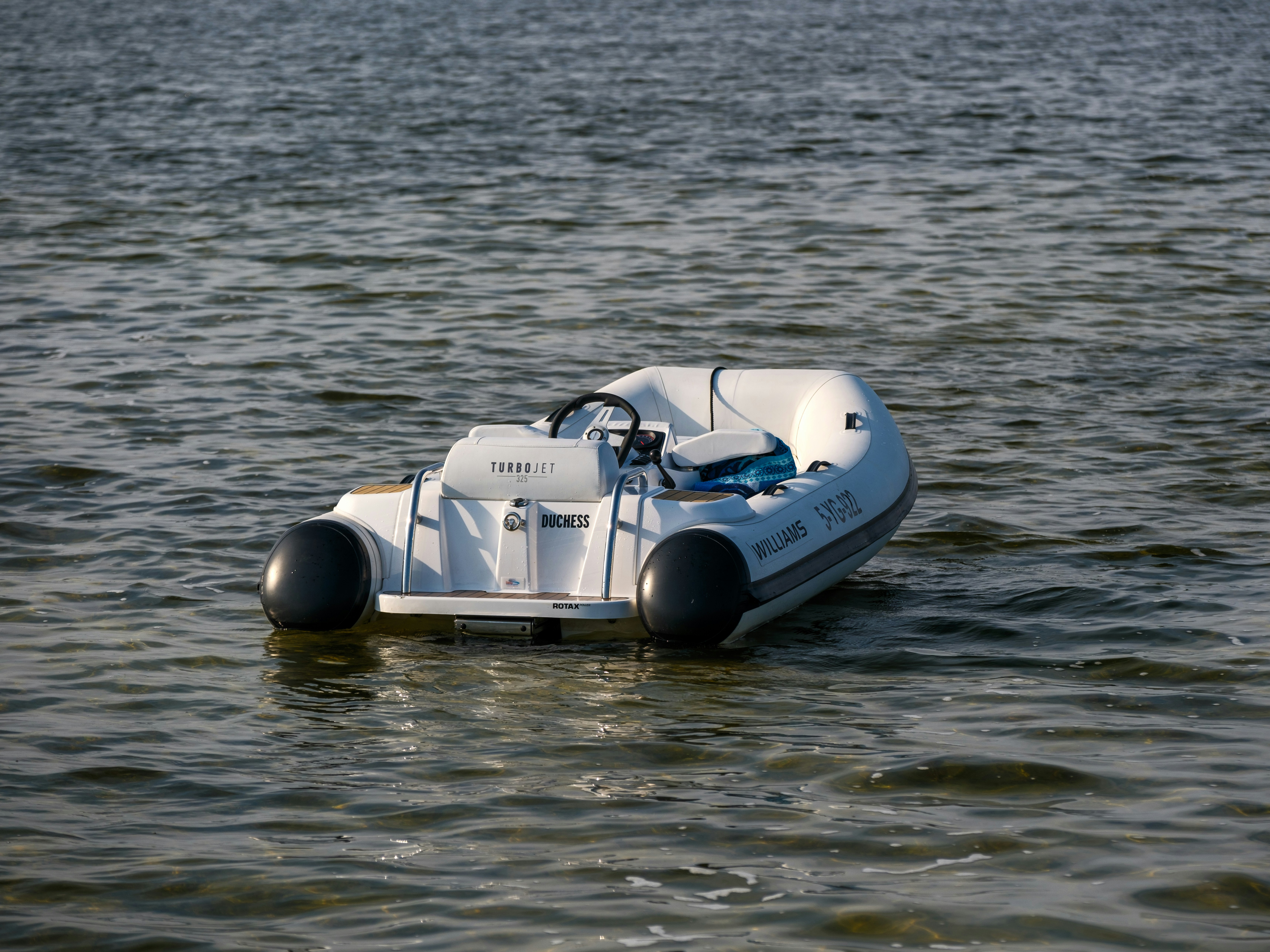 A small boat floating on top of a lake photo – Free Grey Image on Unsplash