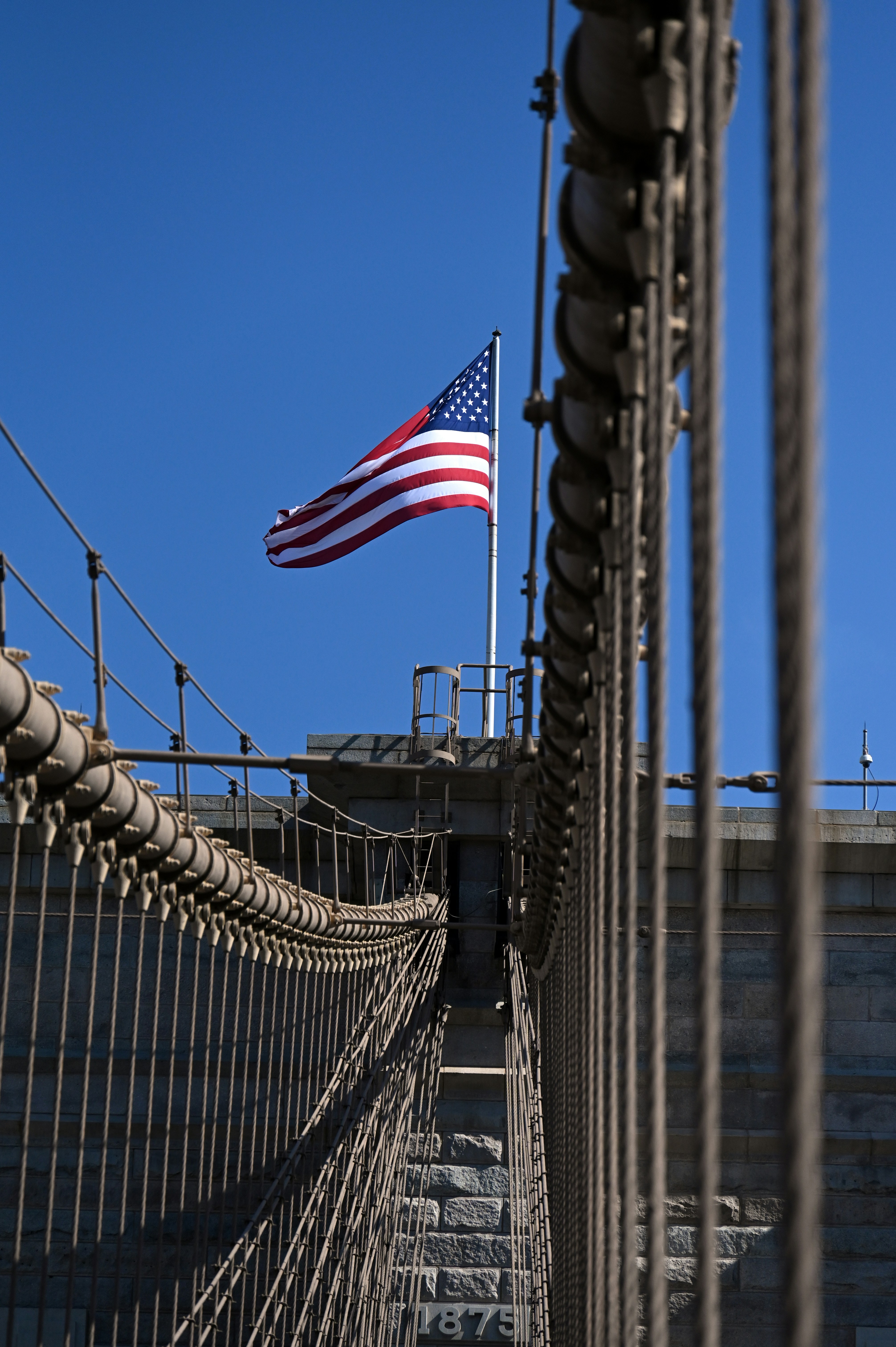 Flag over the Bridge: A Vertical View Along the Suspended Ropes