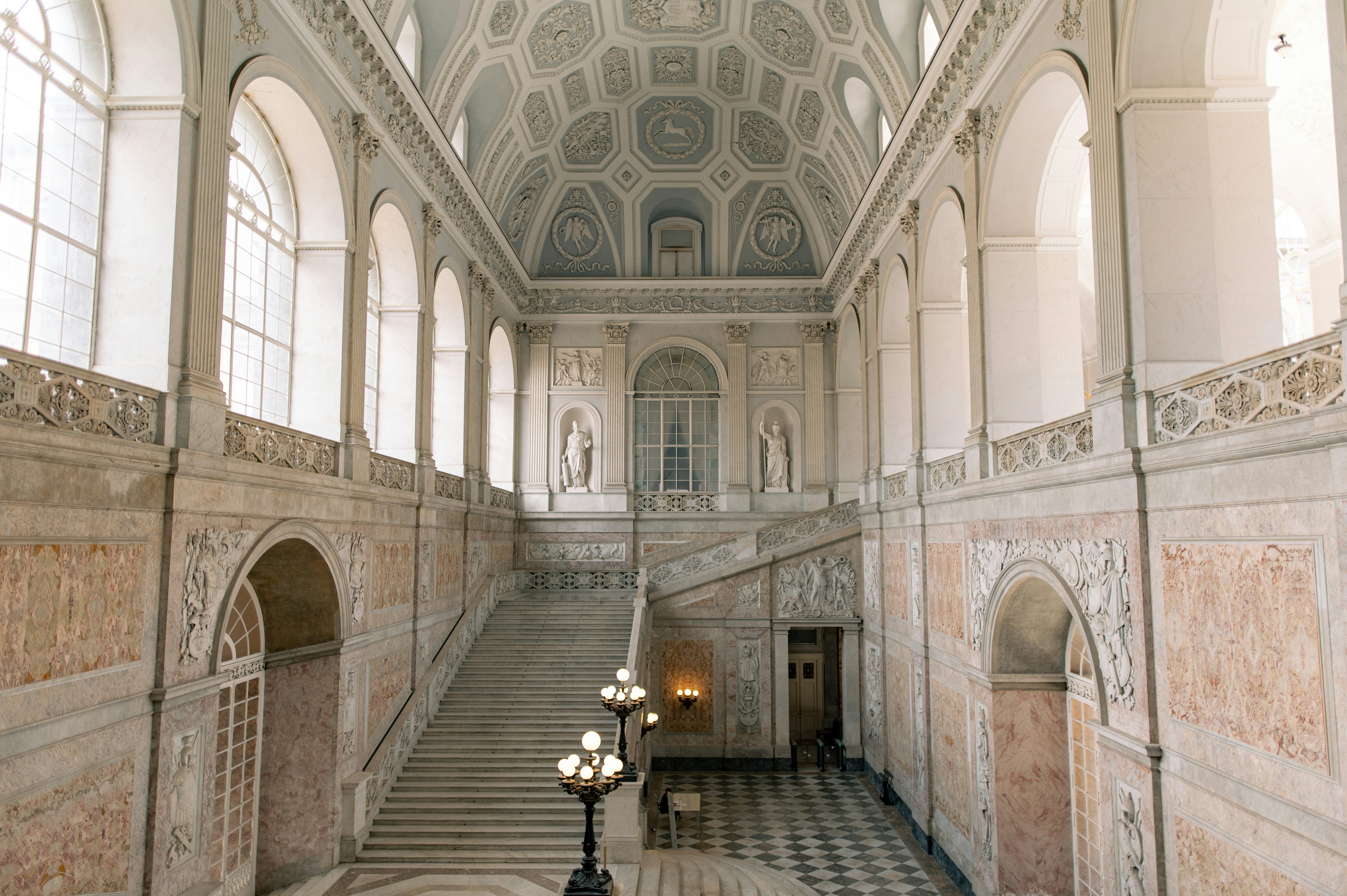 Ornate hallway with large arched windows and intricate ceiling design.
