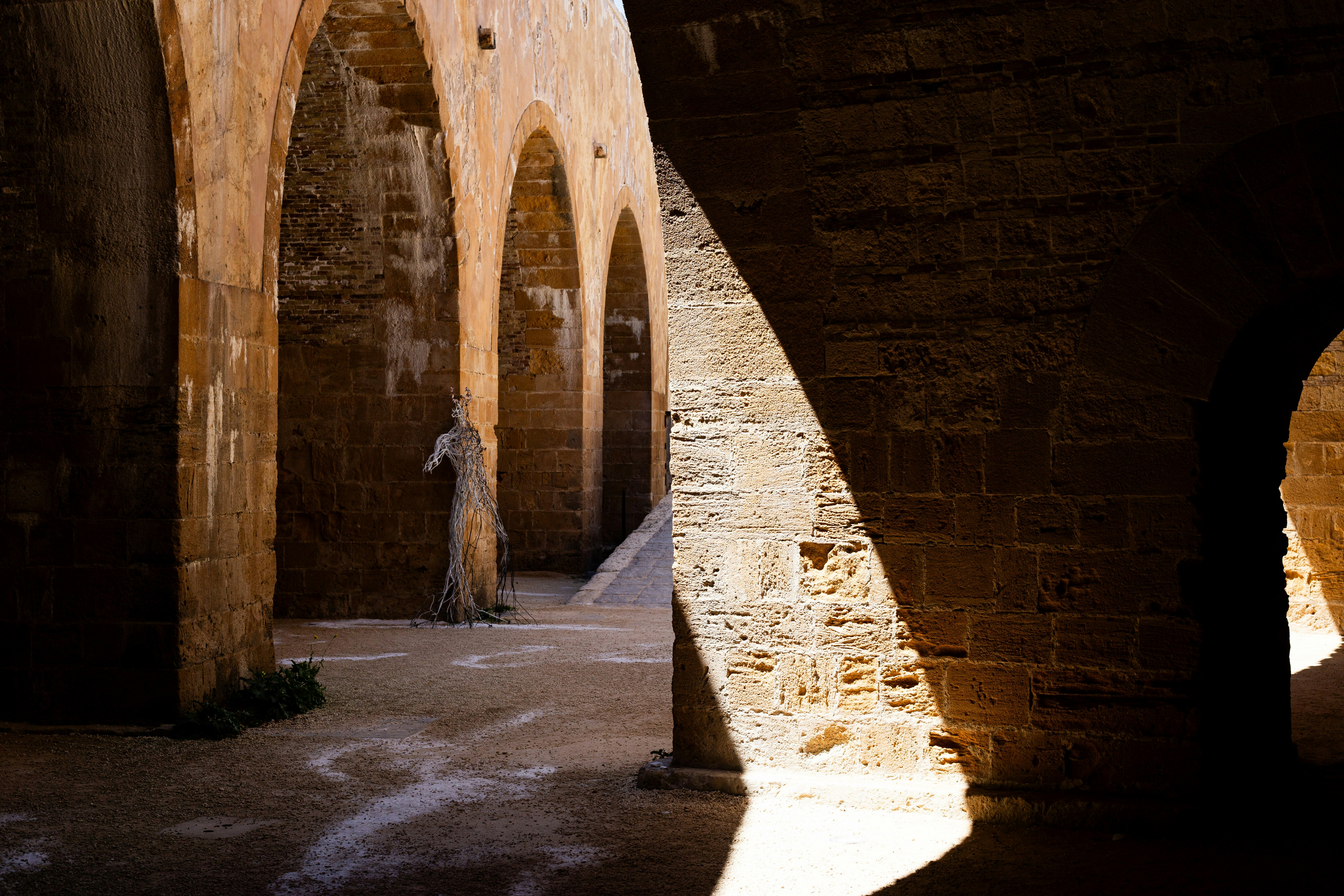 A person standing in a tunnel between two buildings photo – Free Crypt ...
