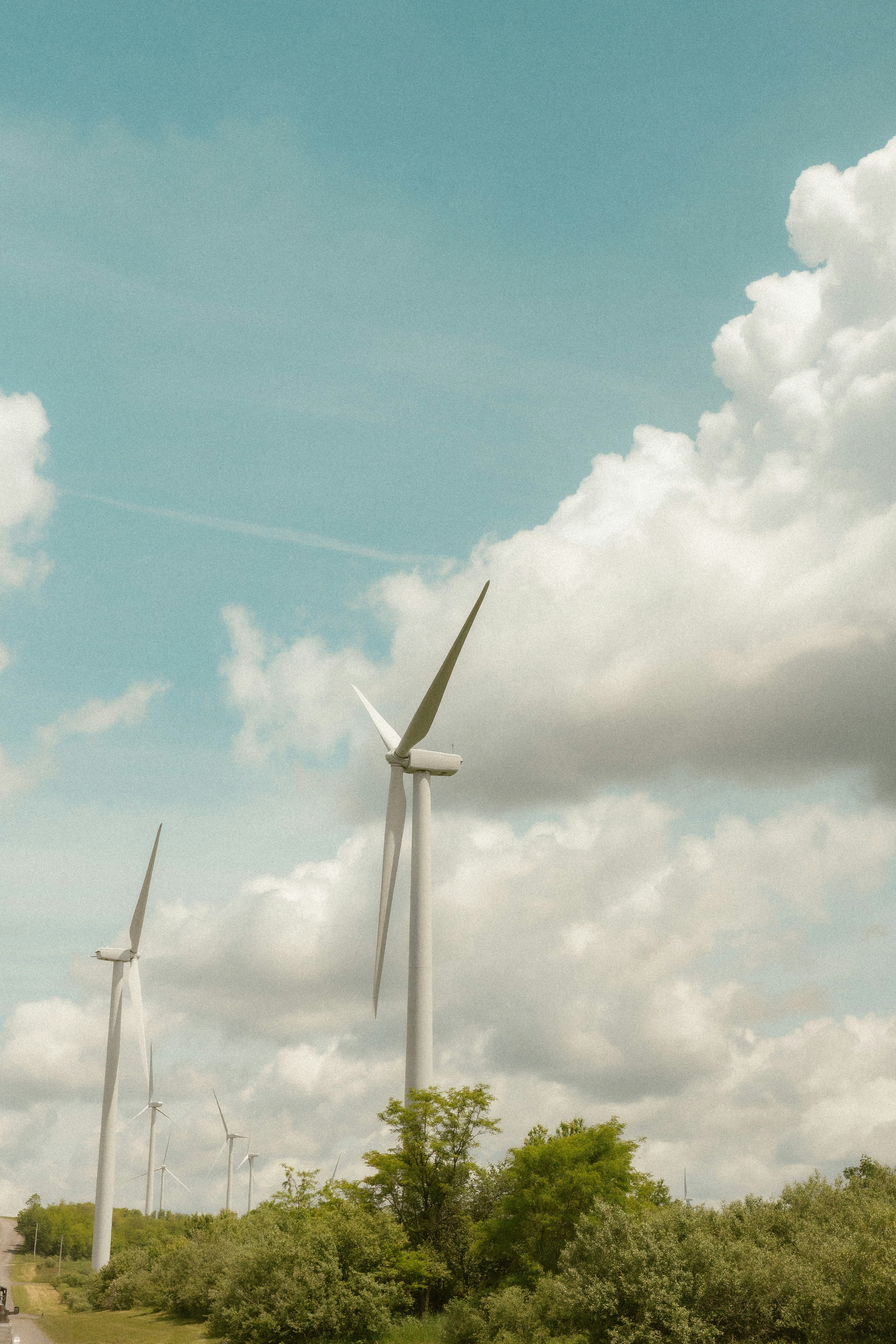 A car driving down a road past wind turbines photo – Free Grey Image on ...