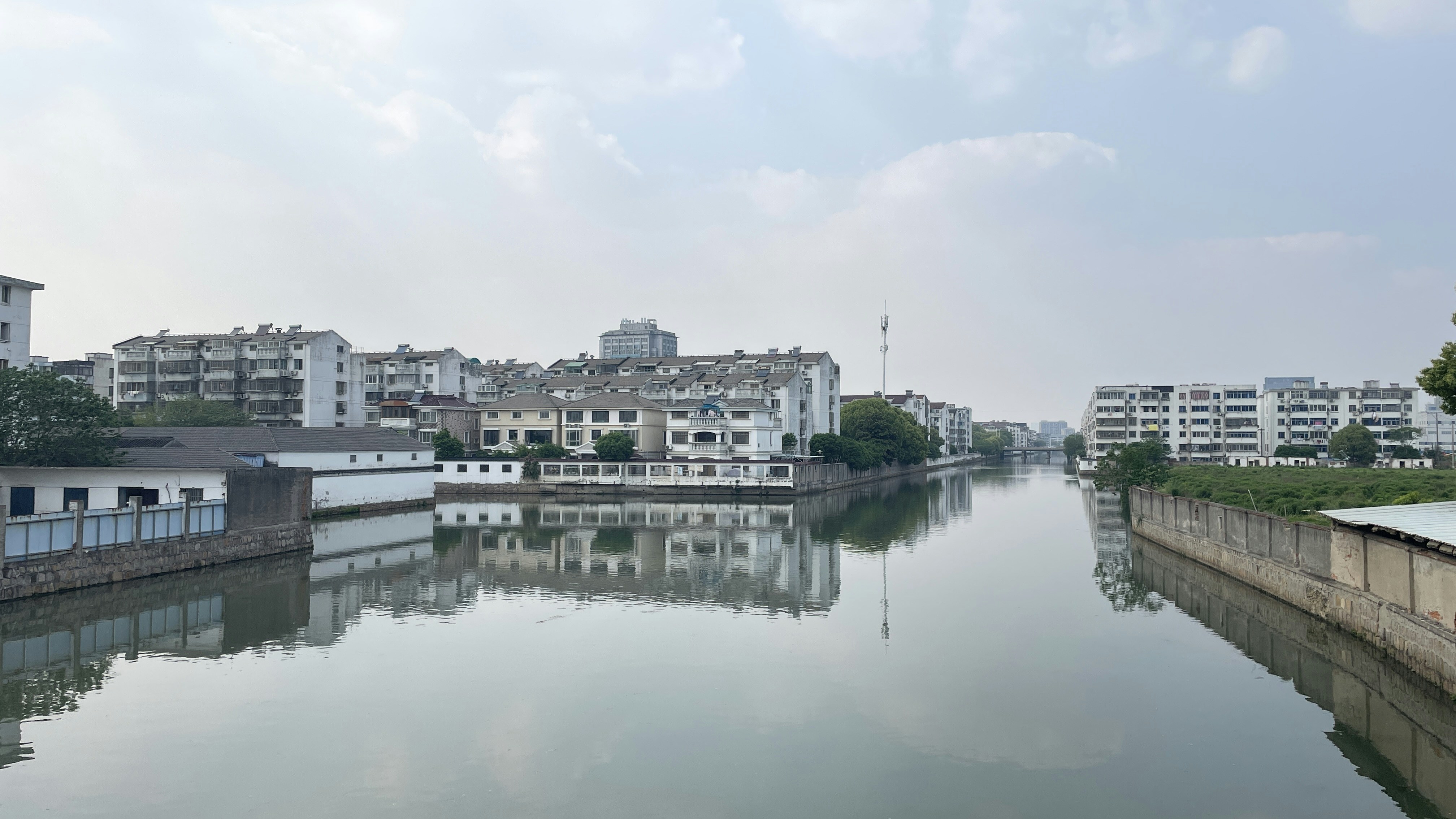 Symmetry Over Water: Riverside Canal Framed by Quiet White Flats