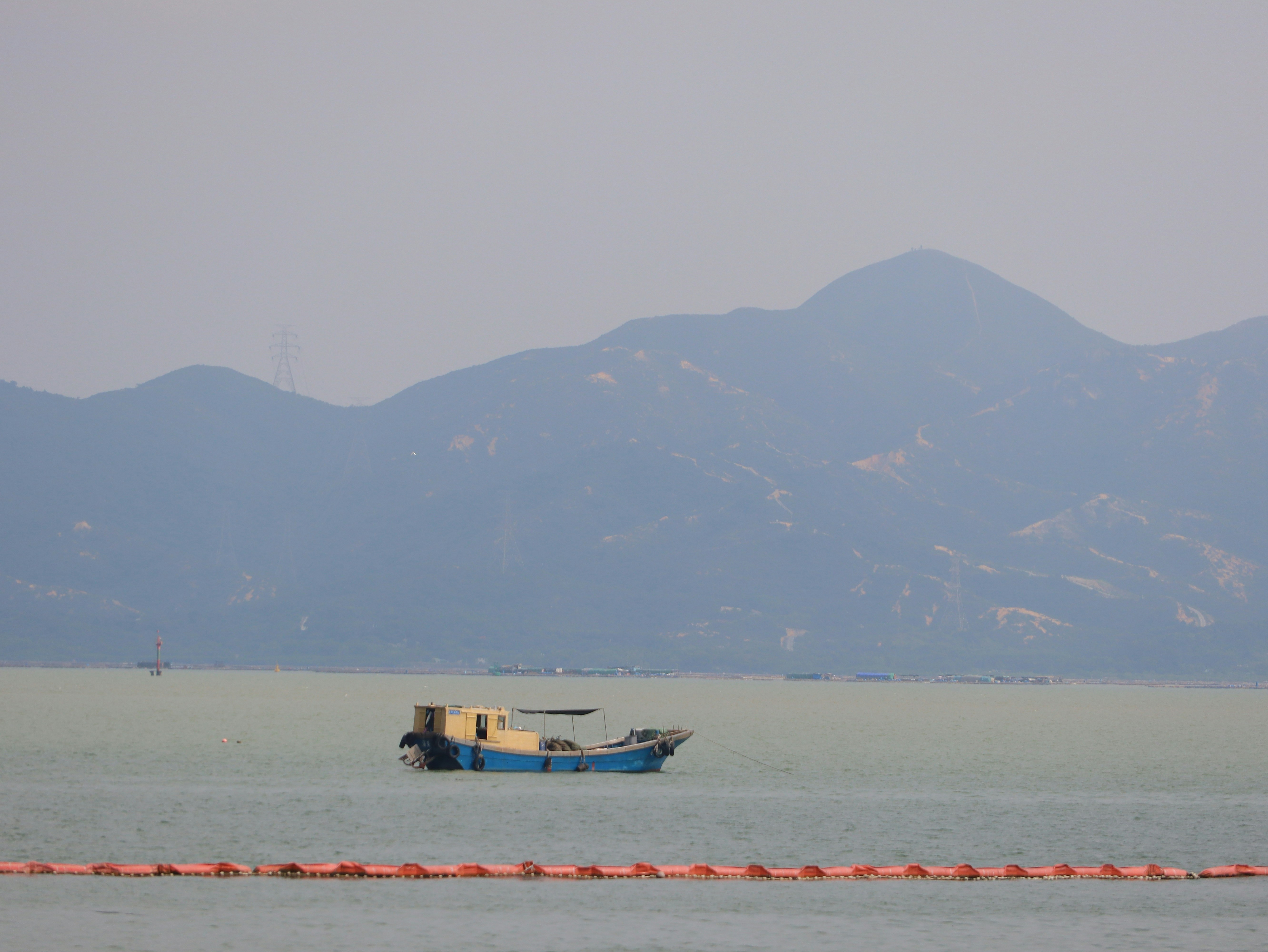 Blue Boat at Quiet Fjord: Misty Mountains Framing a Serene Seascape