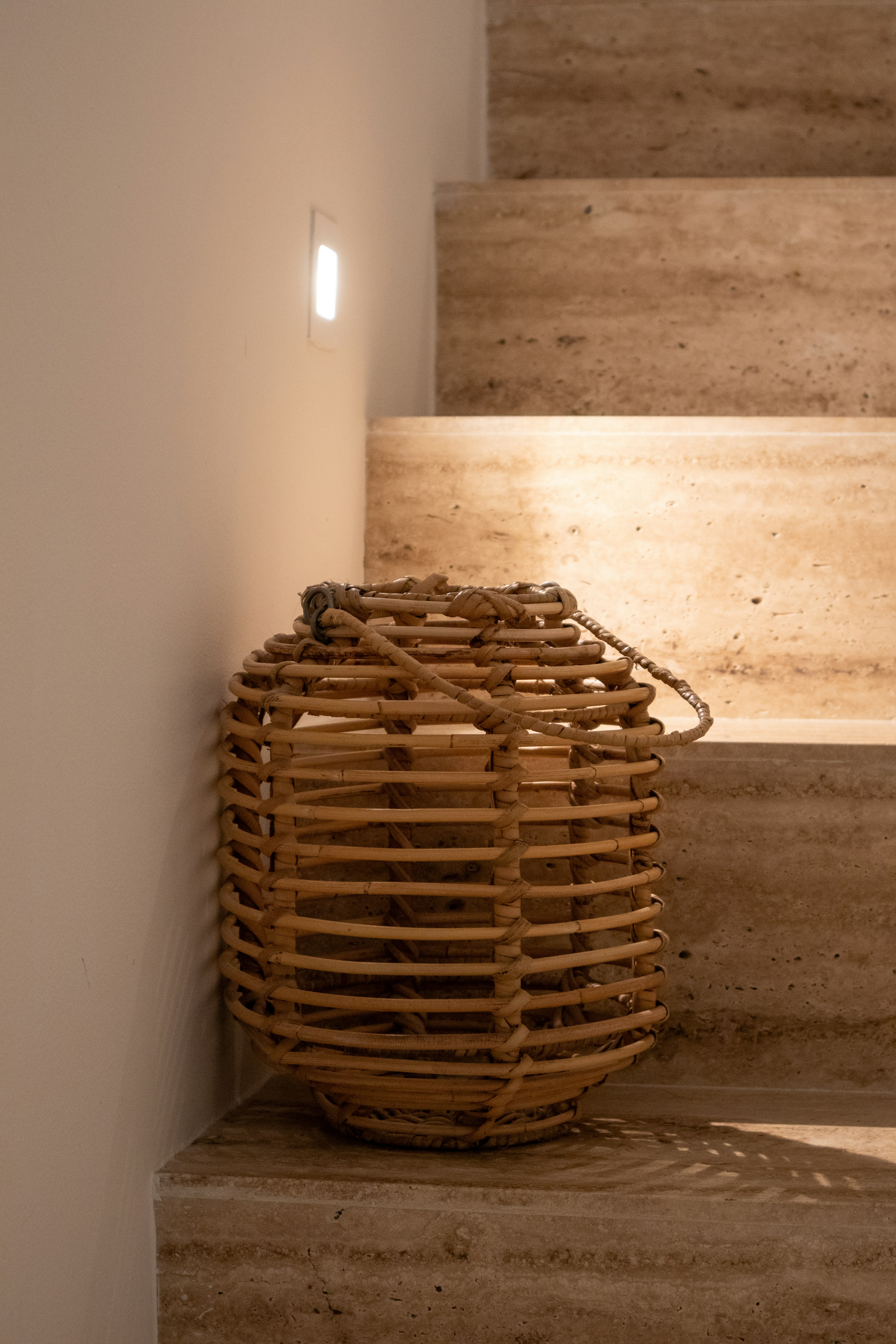 Wicker Basket Anchored to the Foot of a Warm-Stone Staircase