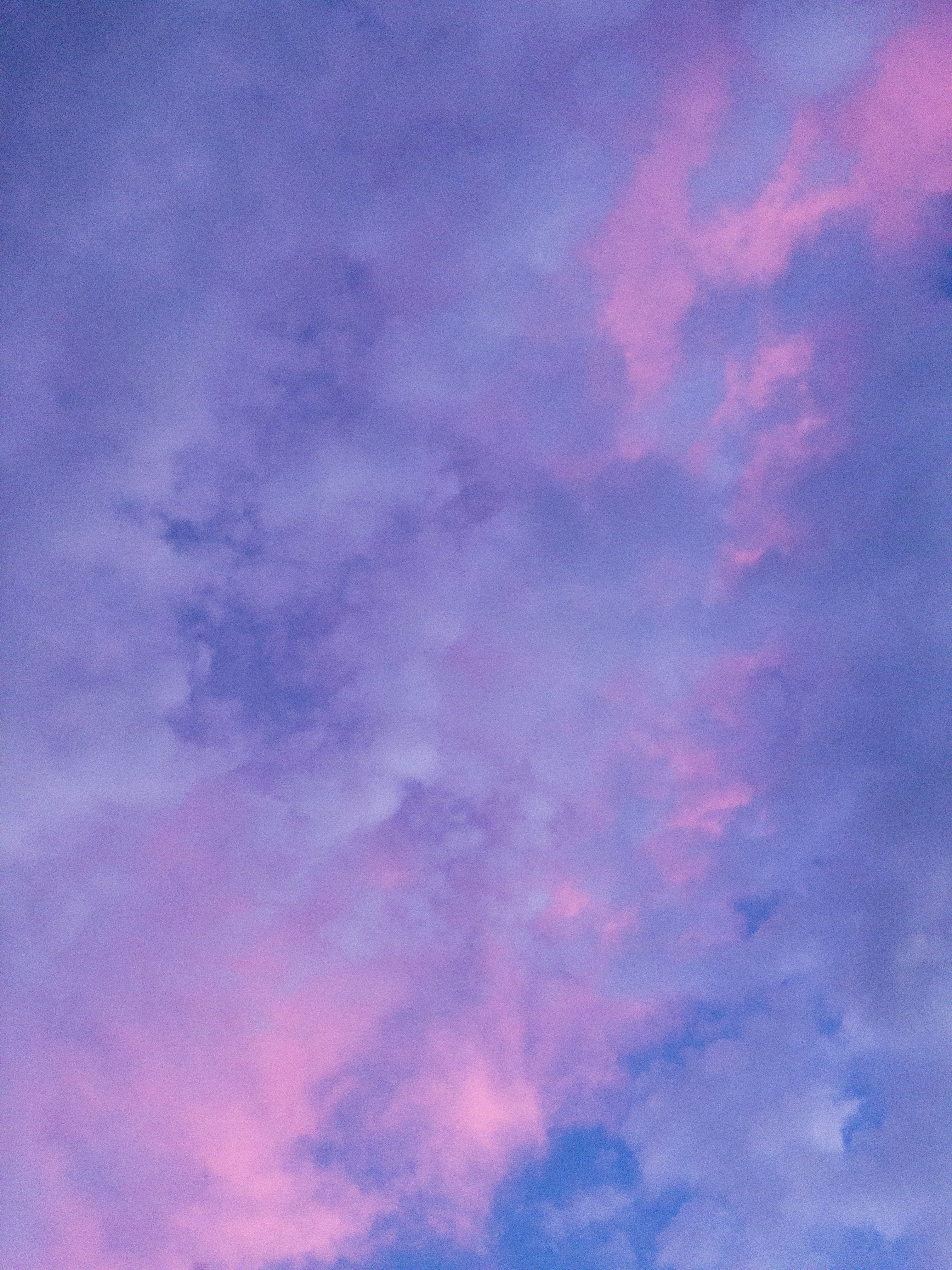 A plane flying in the sky with a pink and blue skyAlex Kalinin