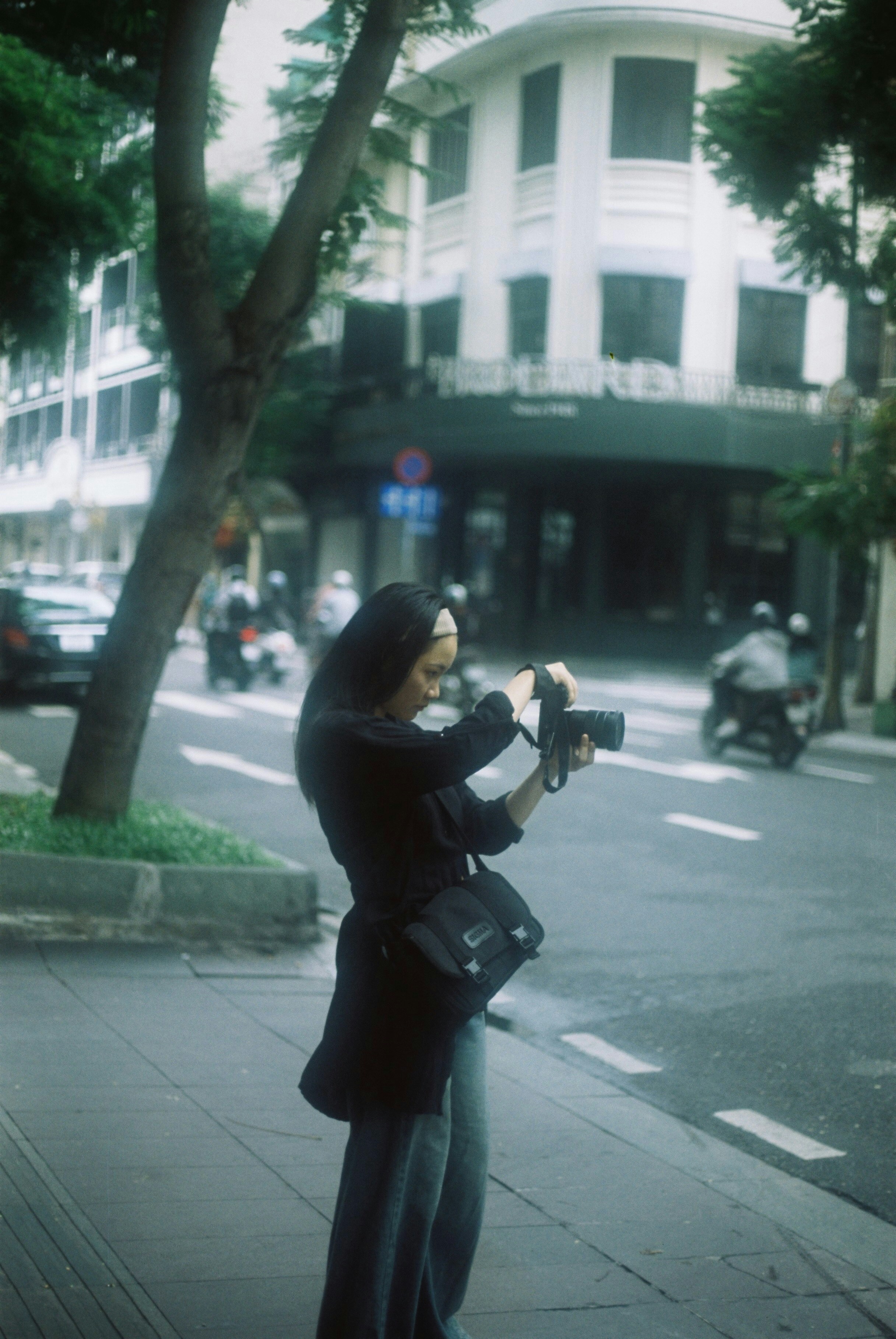 Street Photographer in Focus: A Quiet Moment Amid Urban Motion