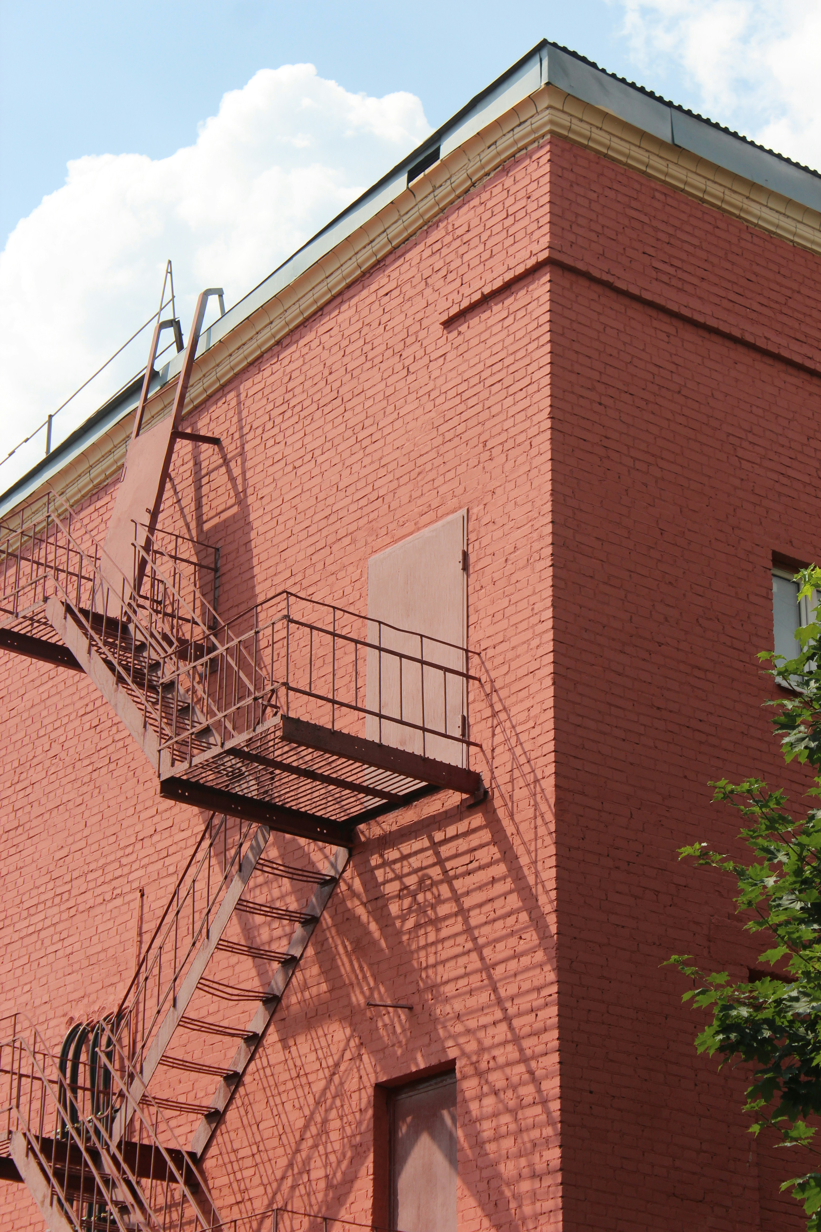 Iron Staircase on a Red Brick Wall: Geometry and Shadows in Afternoon Light
