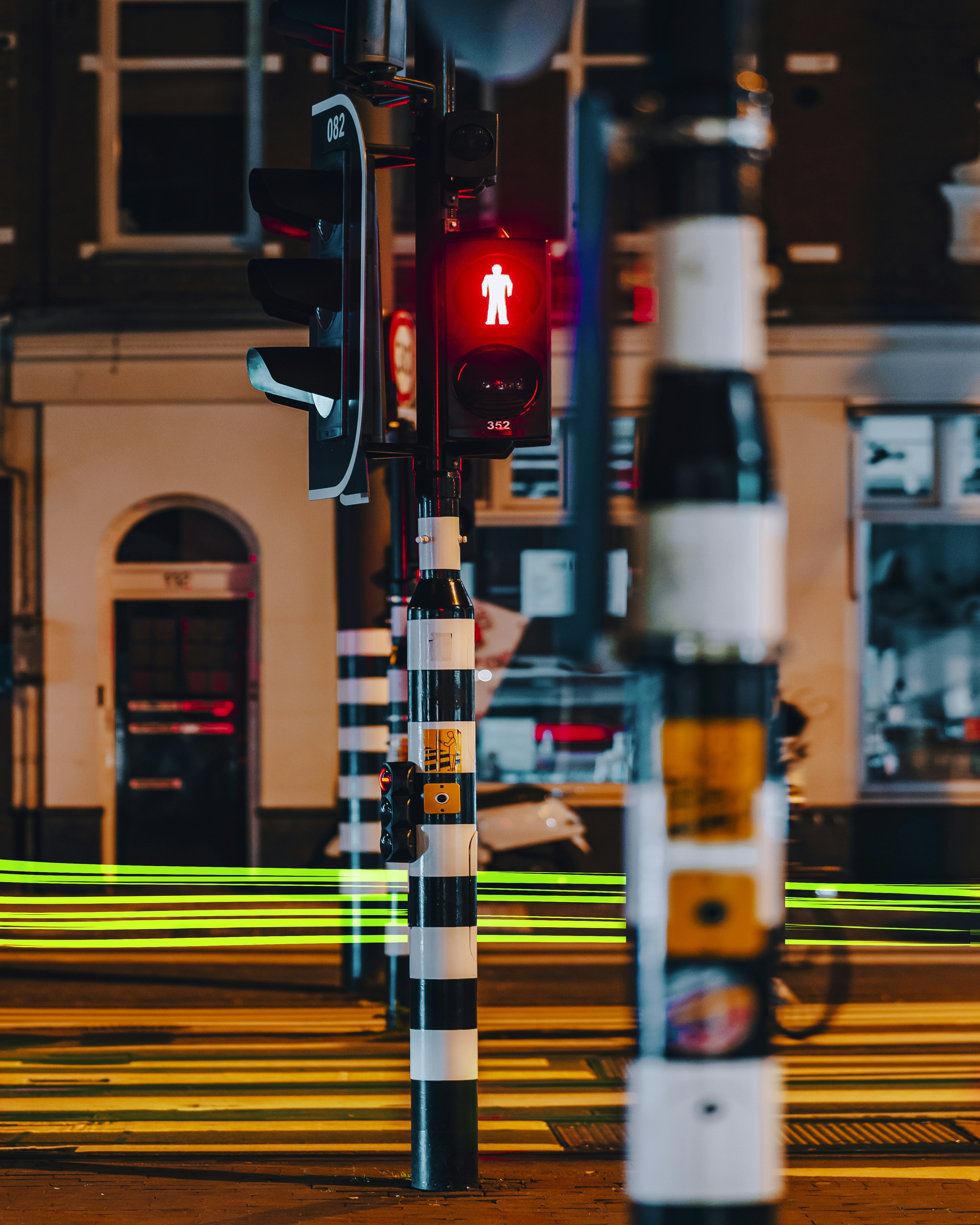 Red Signal Keeps Watch as Neon Traffic Trails Blur Past