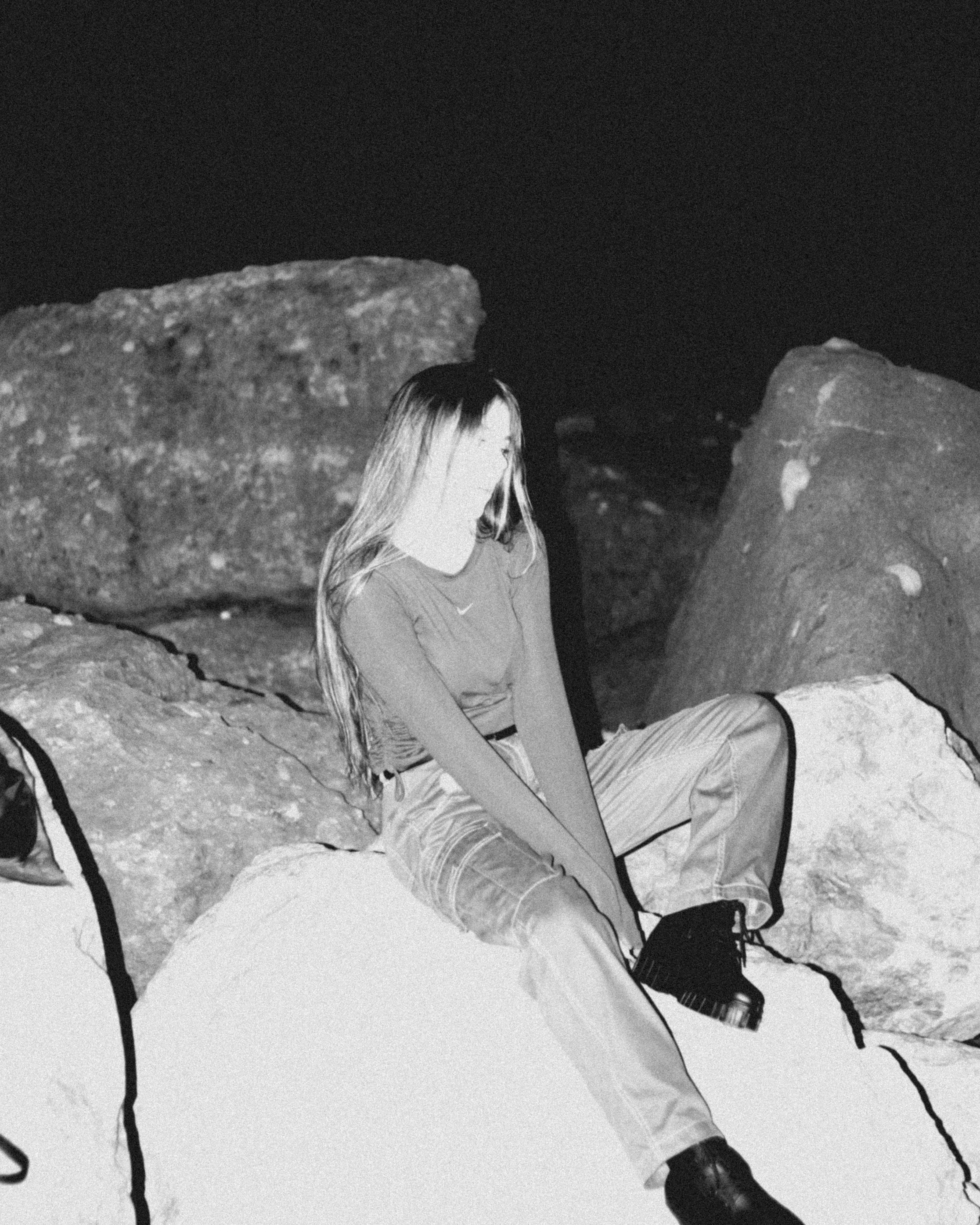 Moonlit solitude: a lone figure on jagged rocks