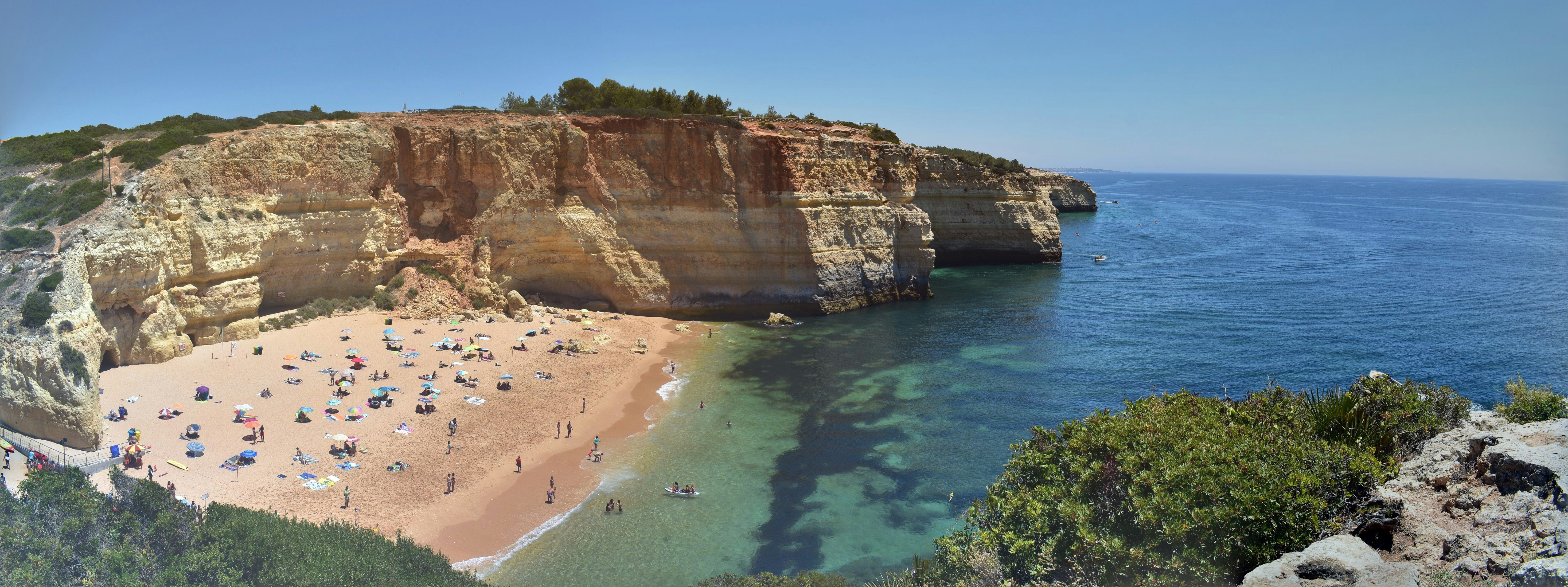 Cliff-Caced Beach: A Sunlit Cove Beneath Rugged Erosion