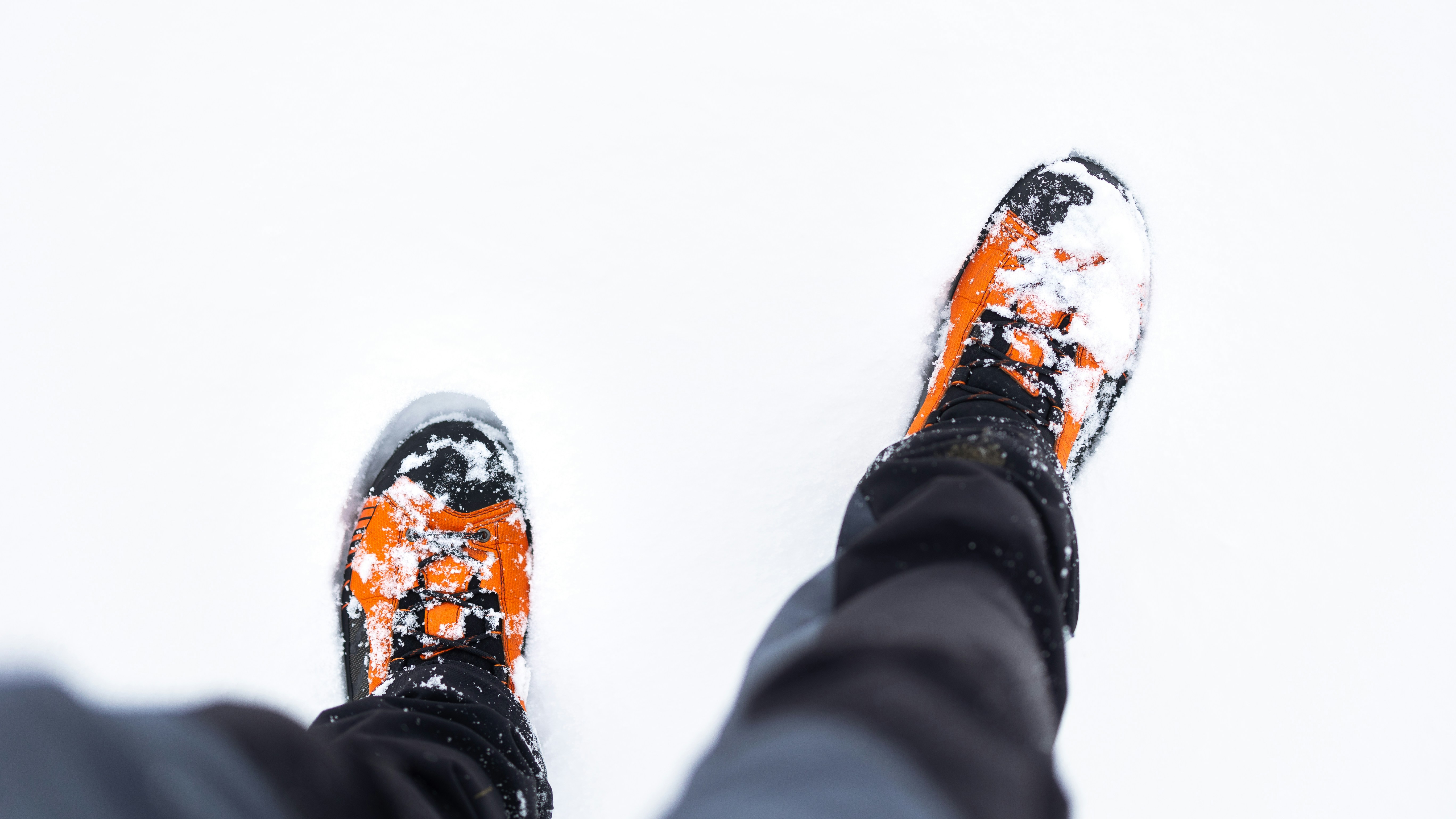A person standing in the snow with their feet up photo – Free Snow ...