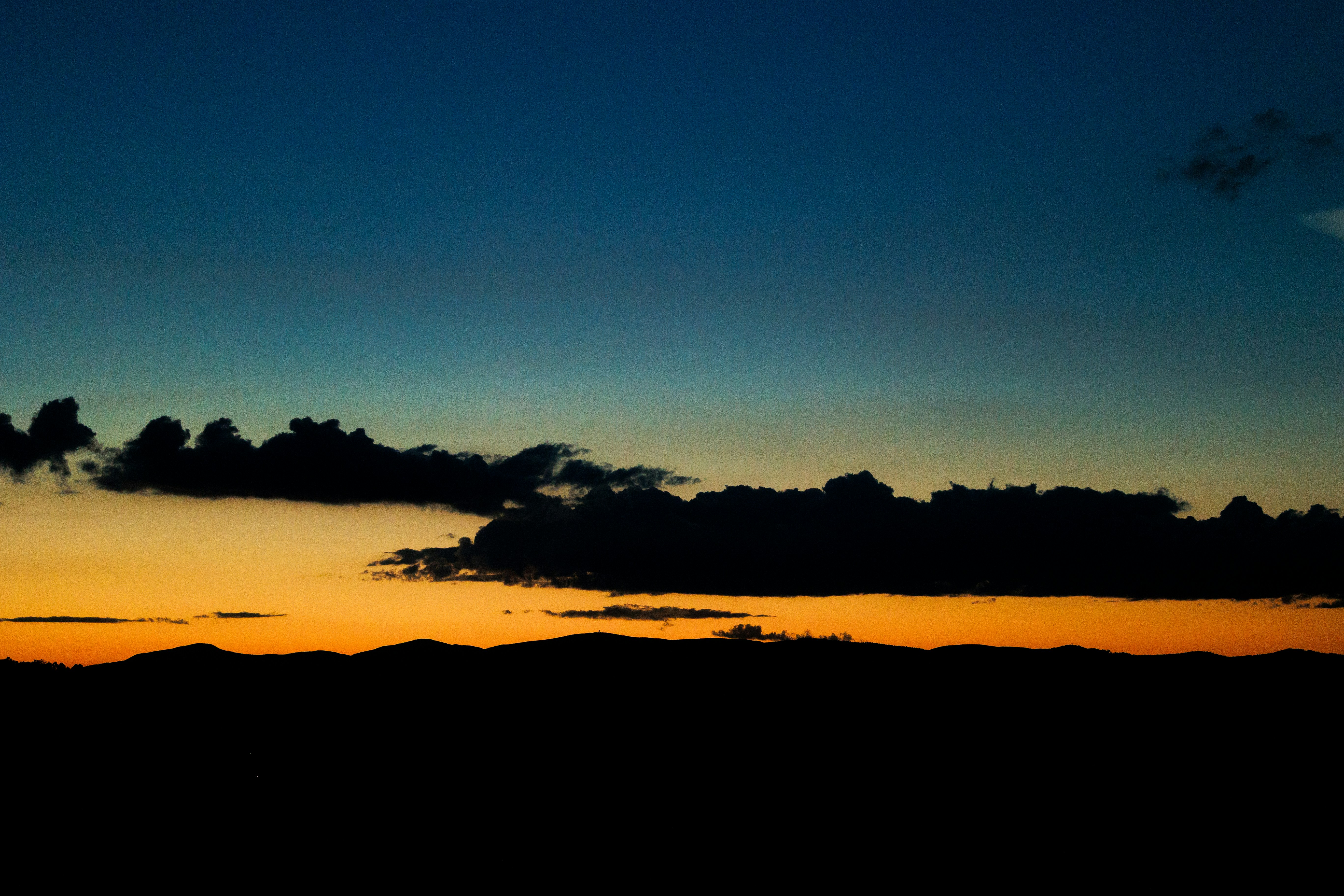 Silhouetted mountains against a vibrant, colorful sunset sky.