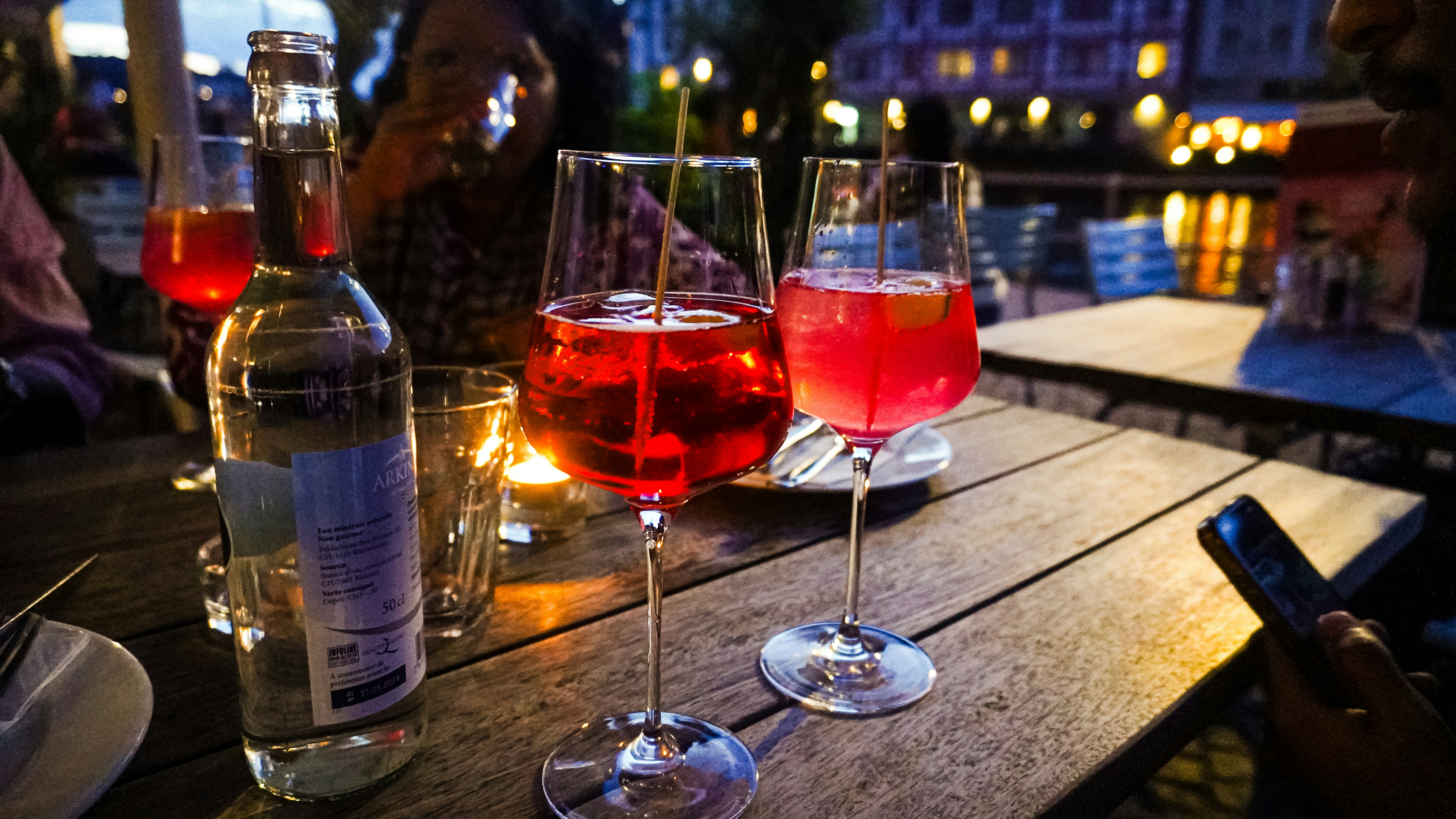 Crimson Toasts and City Lights: A Dusk by the Waterfront